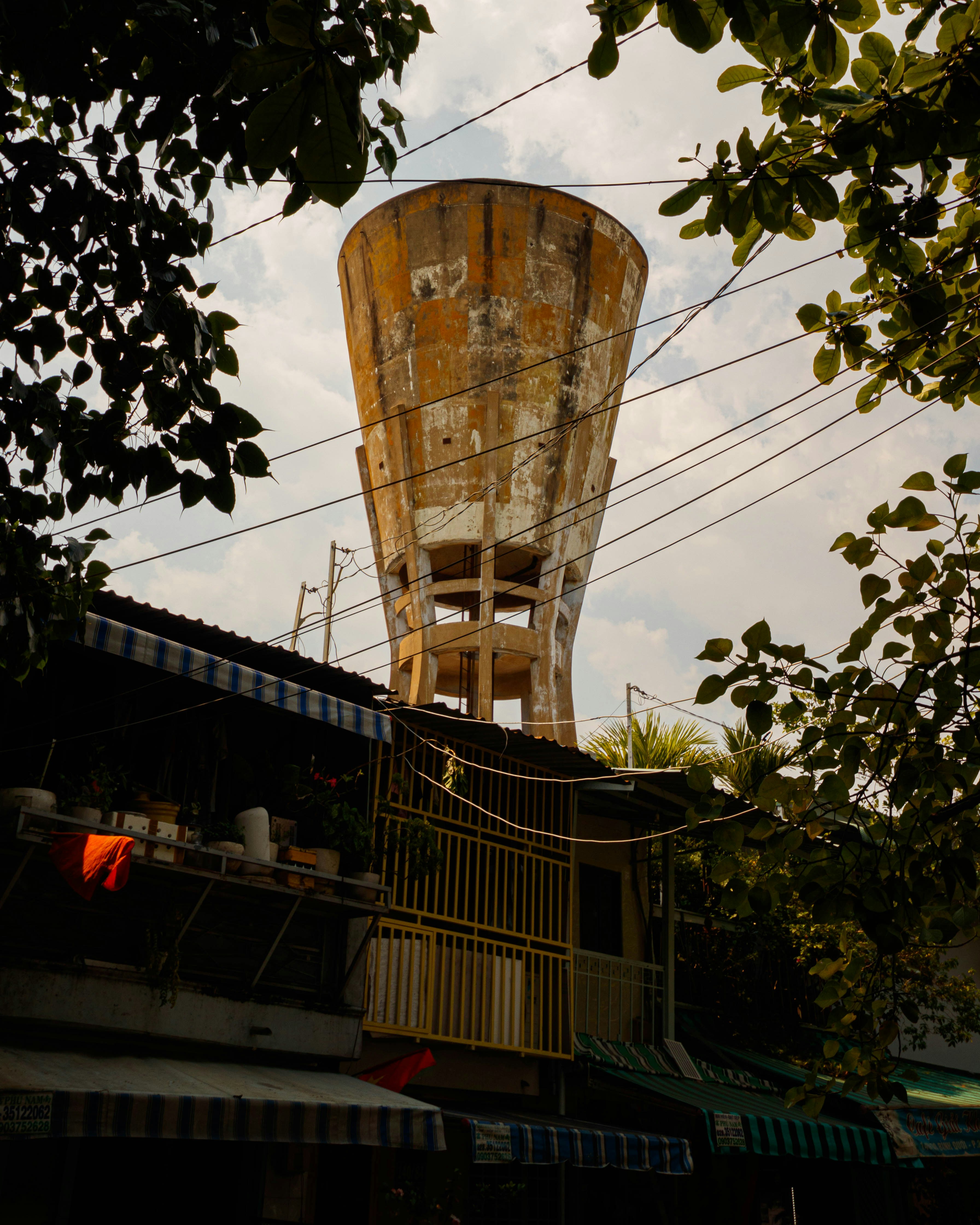Towering Water Tank Rising Above Dappled Marketshops