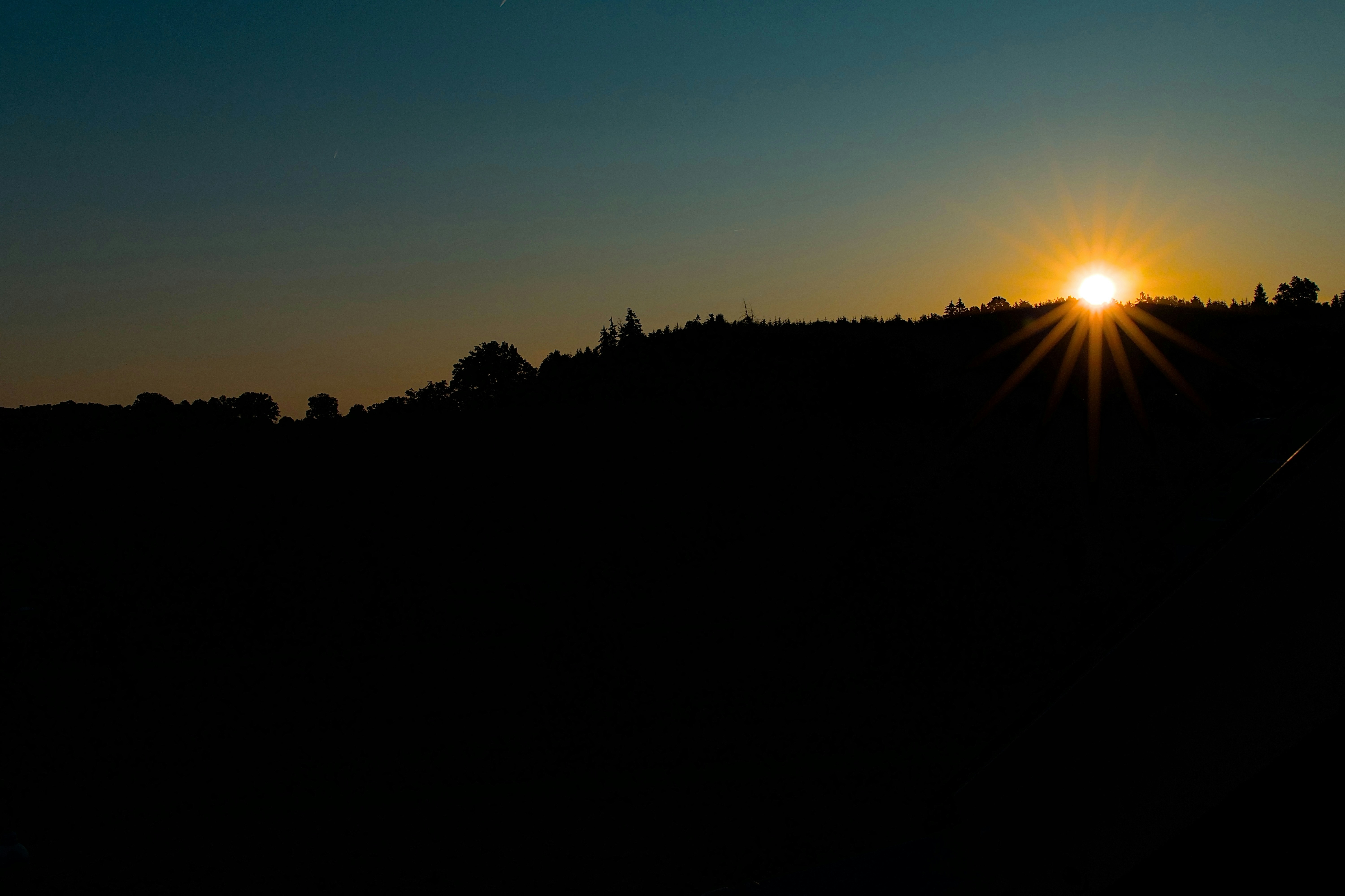 Sunburst on the Ridge: Evening Silhouette over a Quiet Horizon
