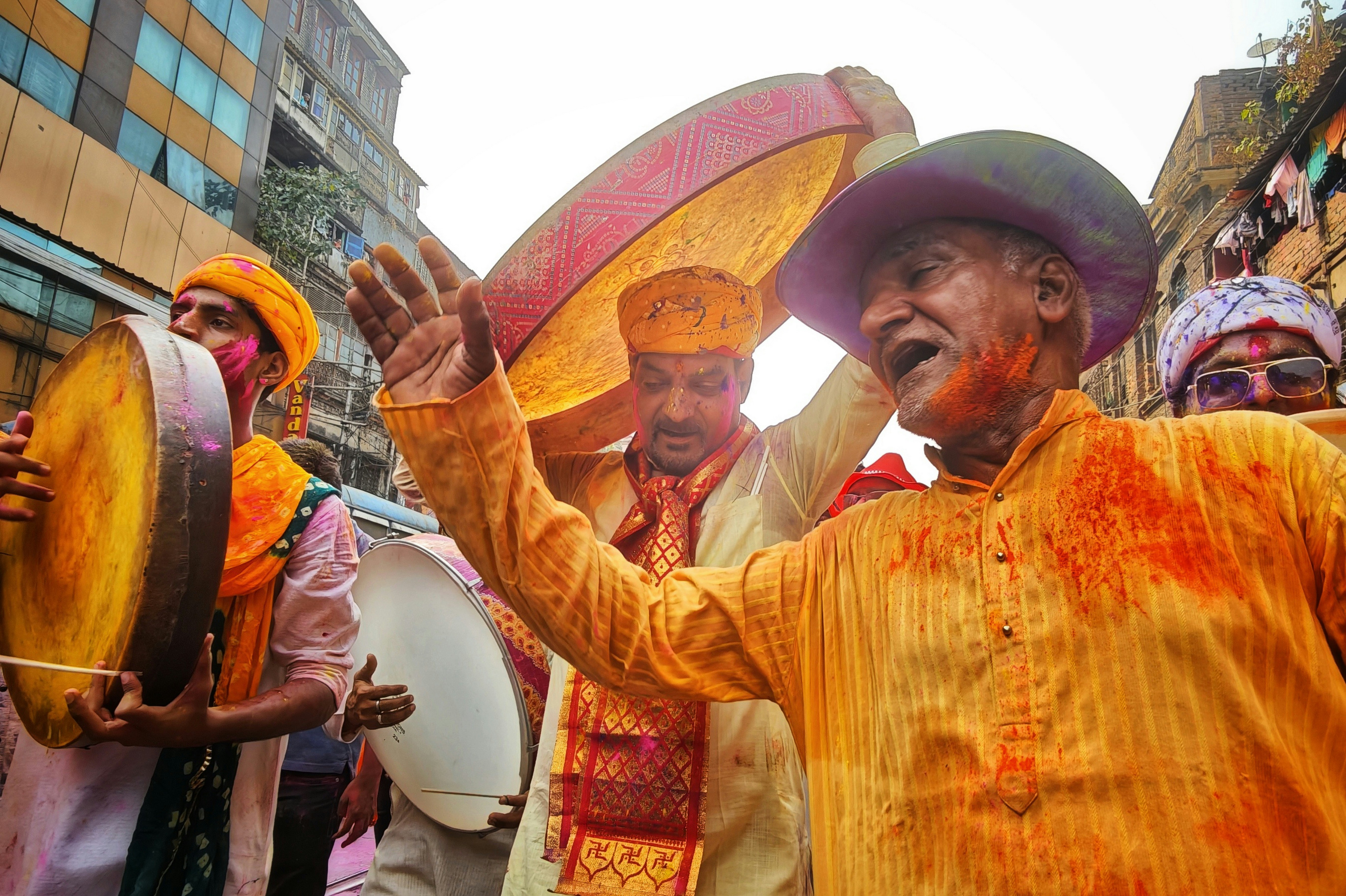 Vibrant Holi Procession: Faces, Colors, and Drums in the Street