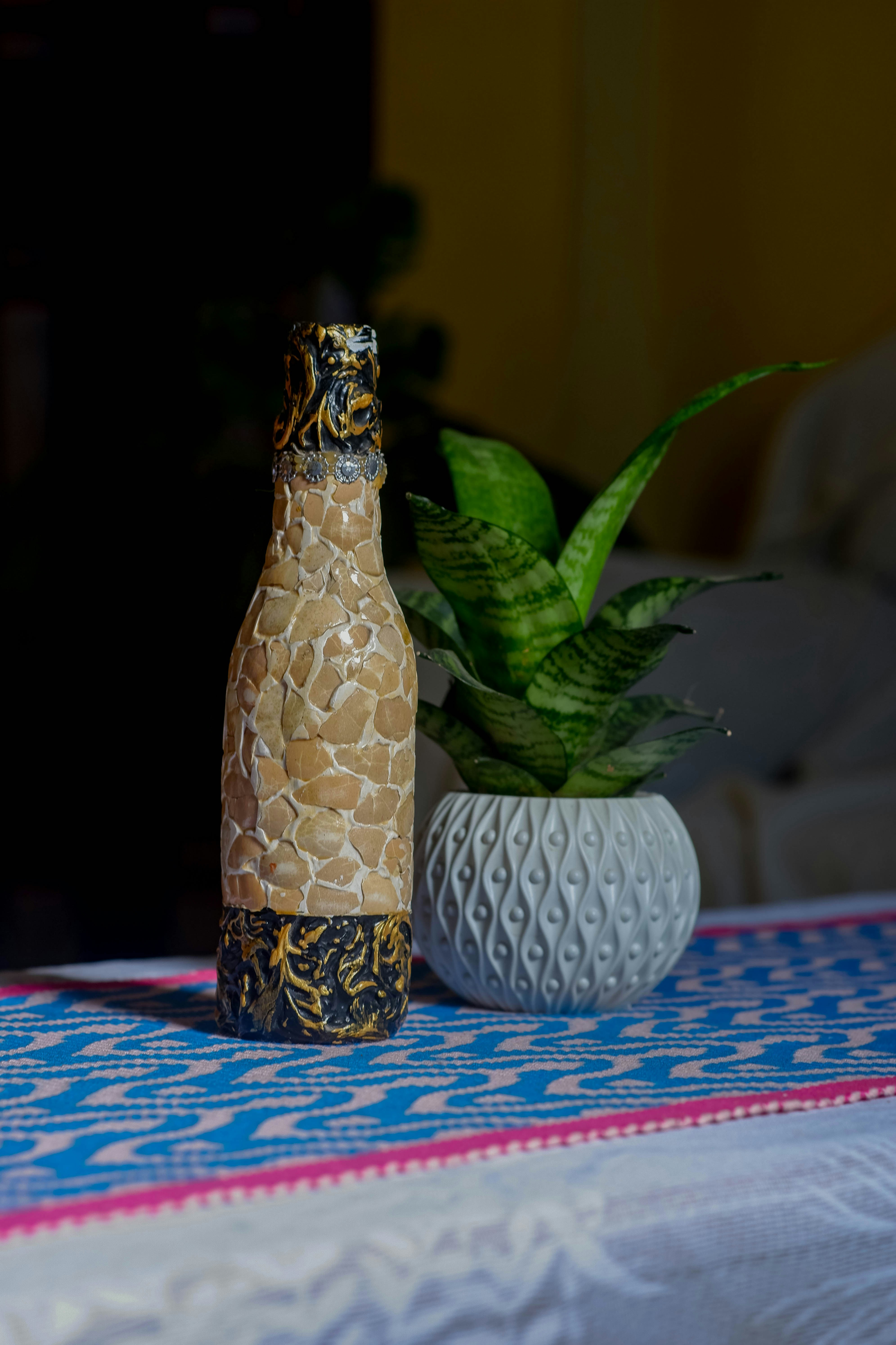 Gilded Bottle and Dainty Fern Against a Velvet Backdrop