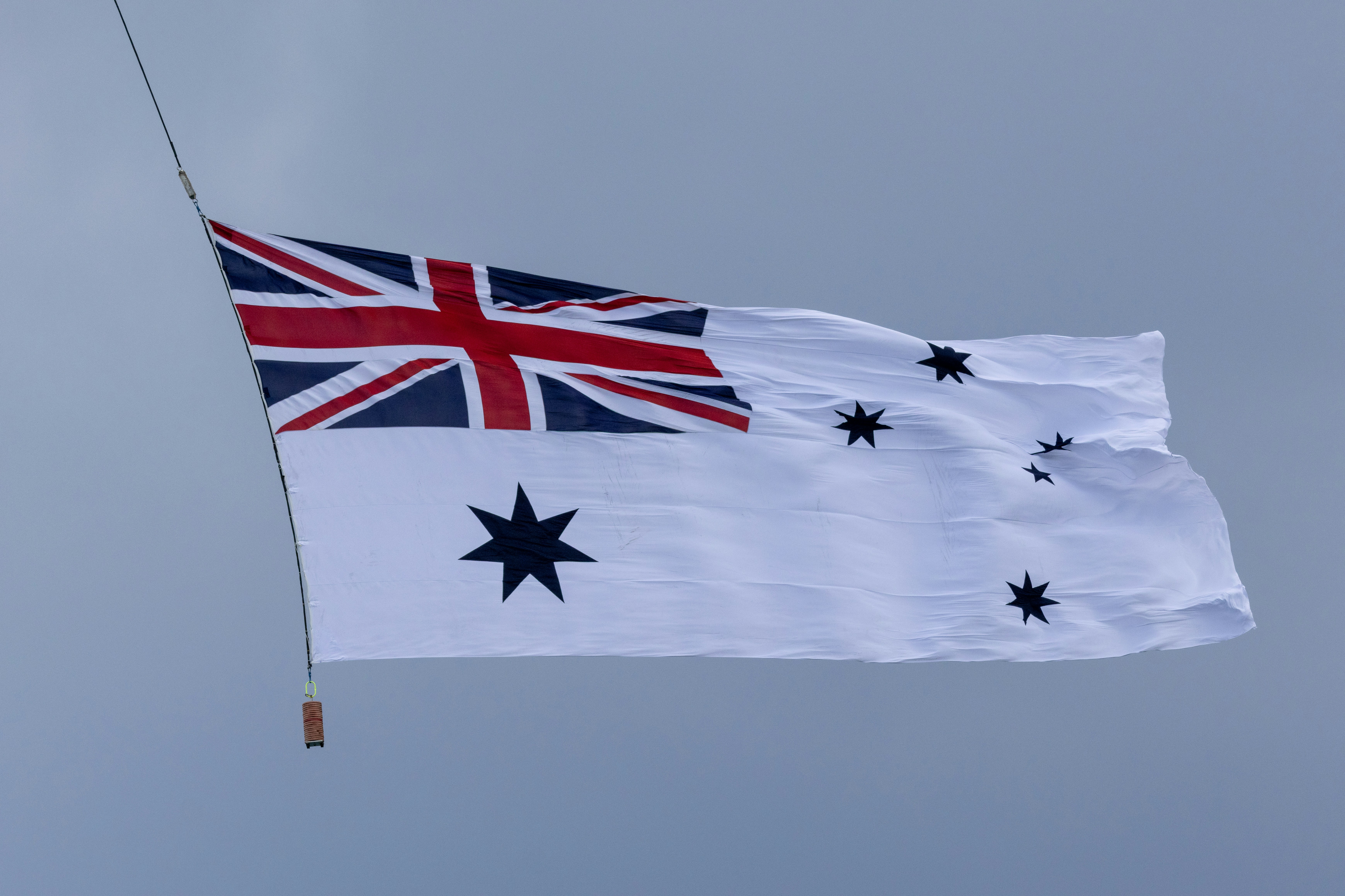 Flag in the Wind: The Australian Flag Galloping Across a Clear Sky
