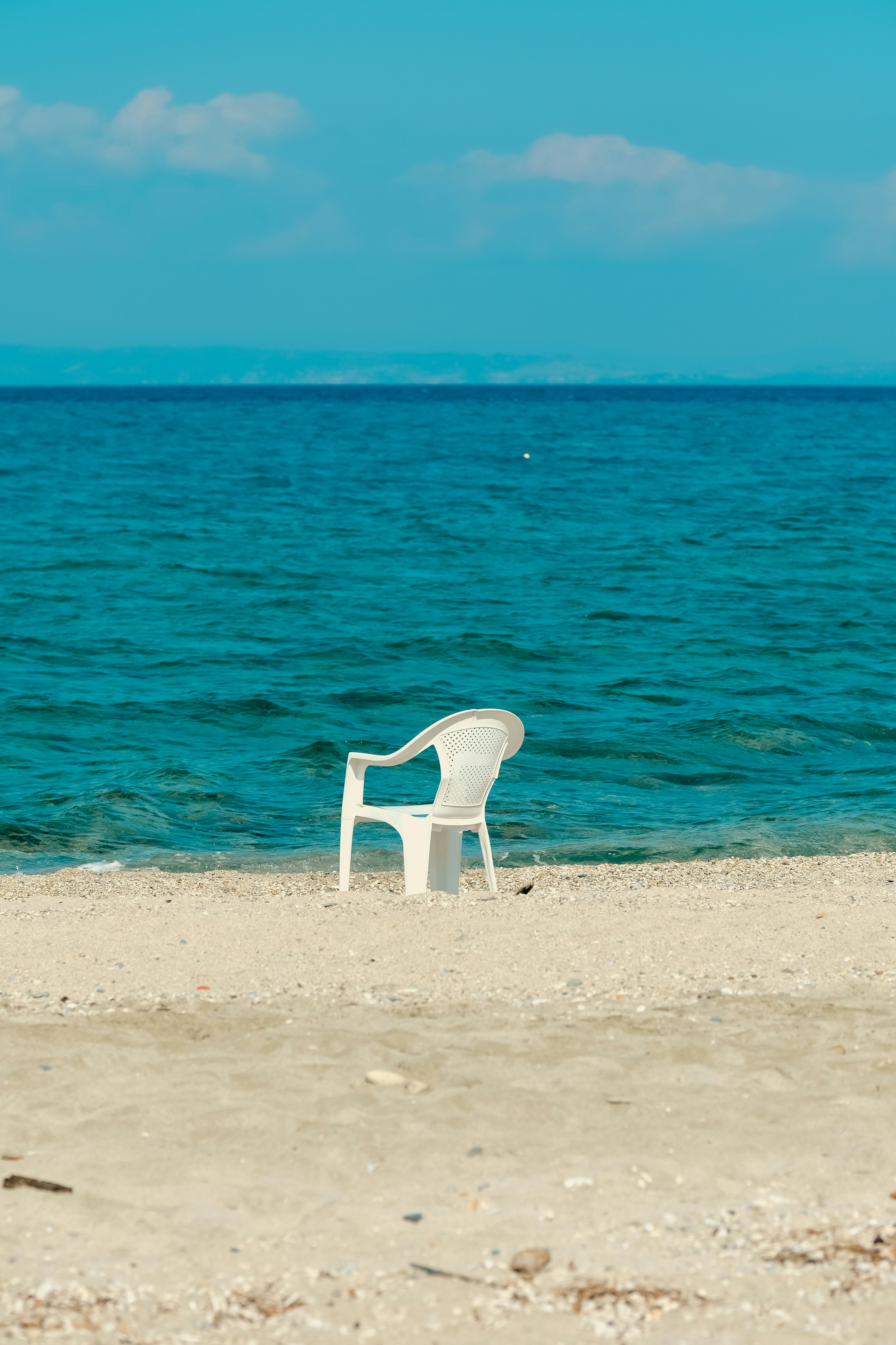 Solitary White Chair Standing Guard Over the Sea