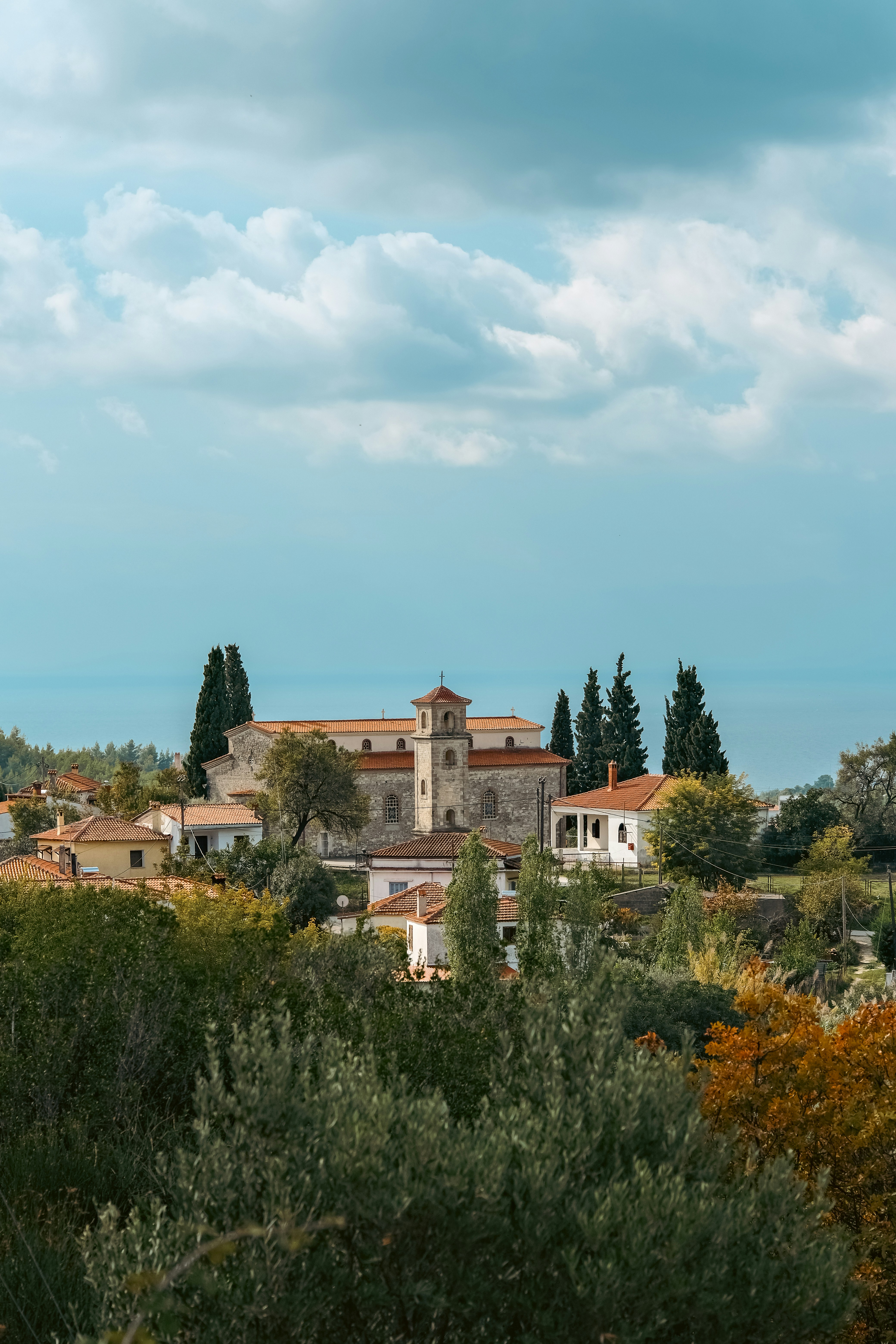 Hilltop Village with Mediterranean Church under a Sky of Soft Clouds
