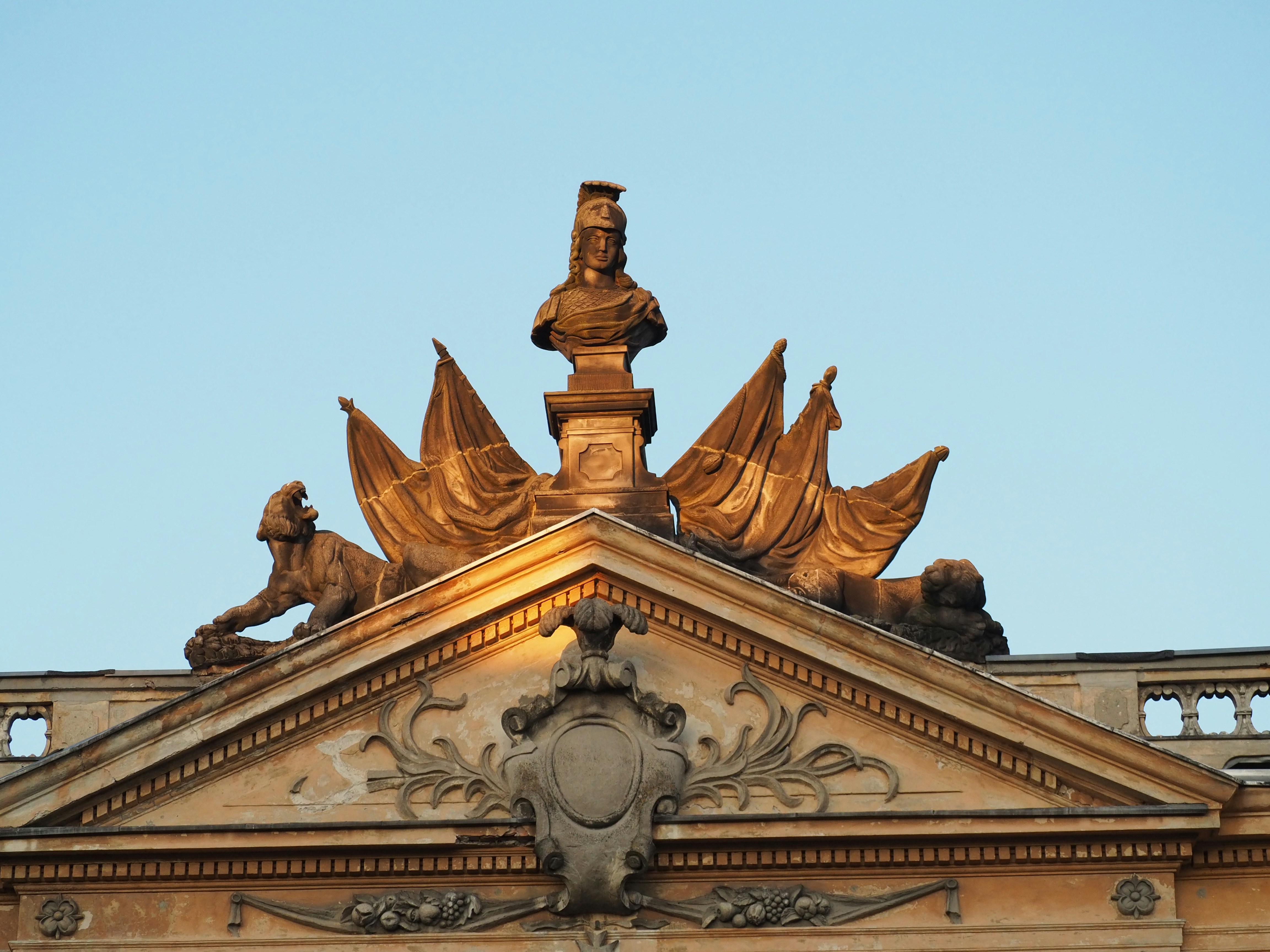 Sunlit Crest: A Historic Gable with Sculpted Guardians