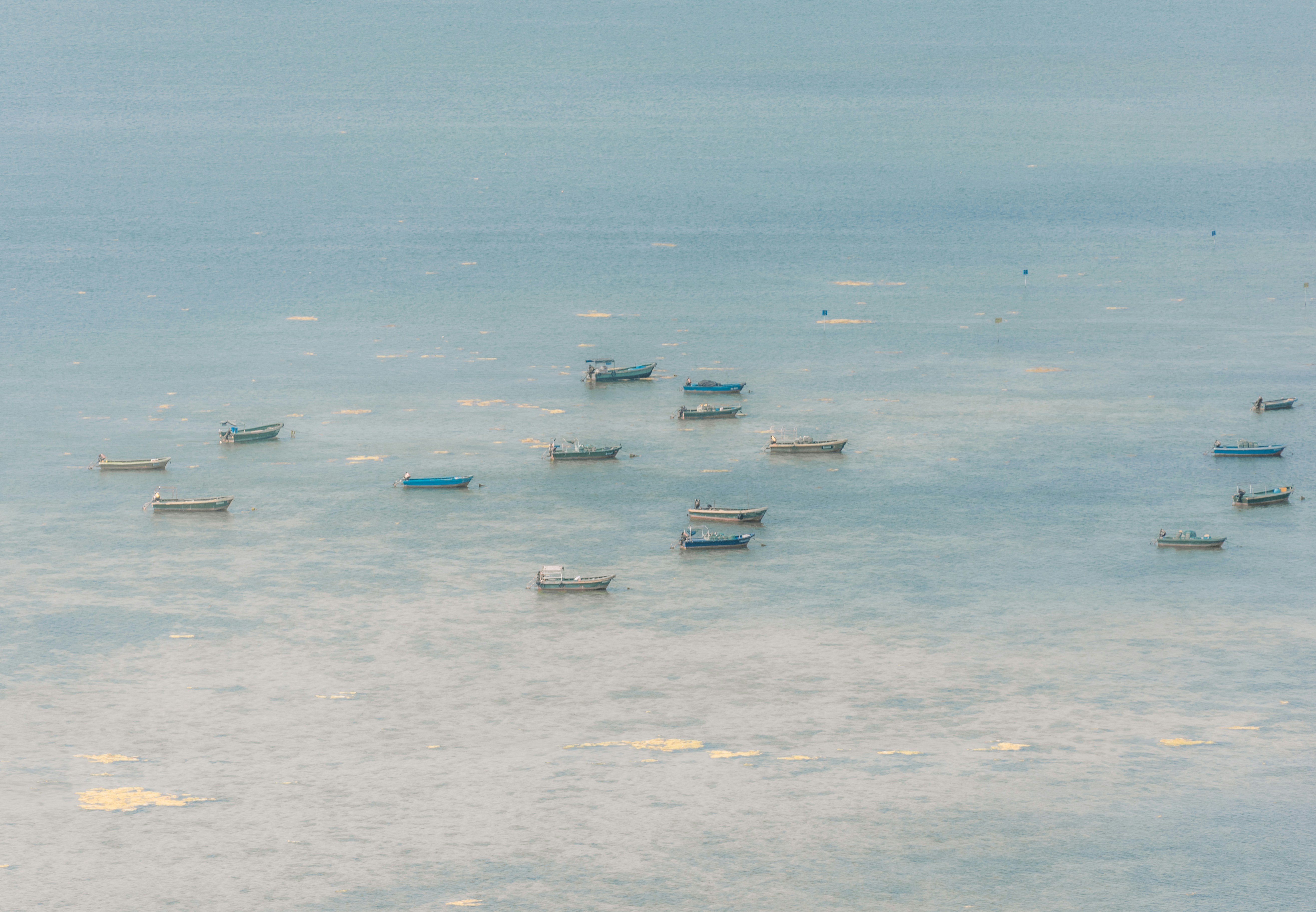 A Fleet of Quiet Boats Drifting in Sunset Mist