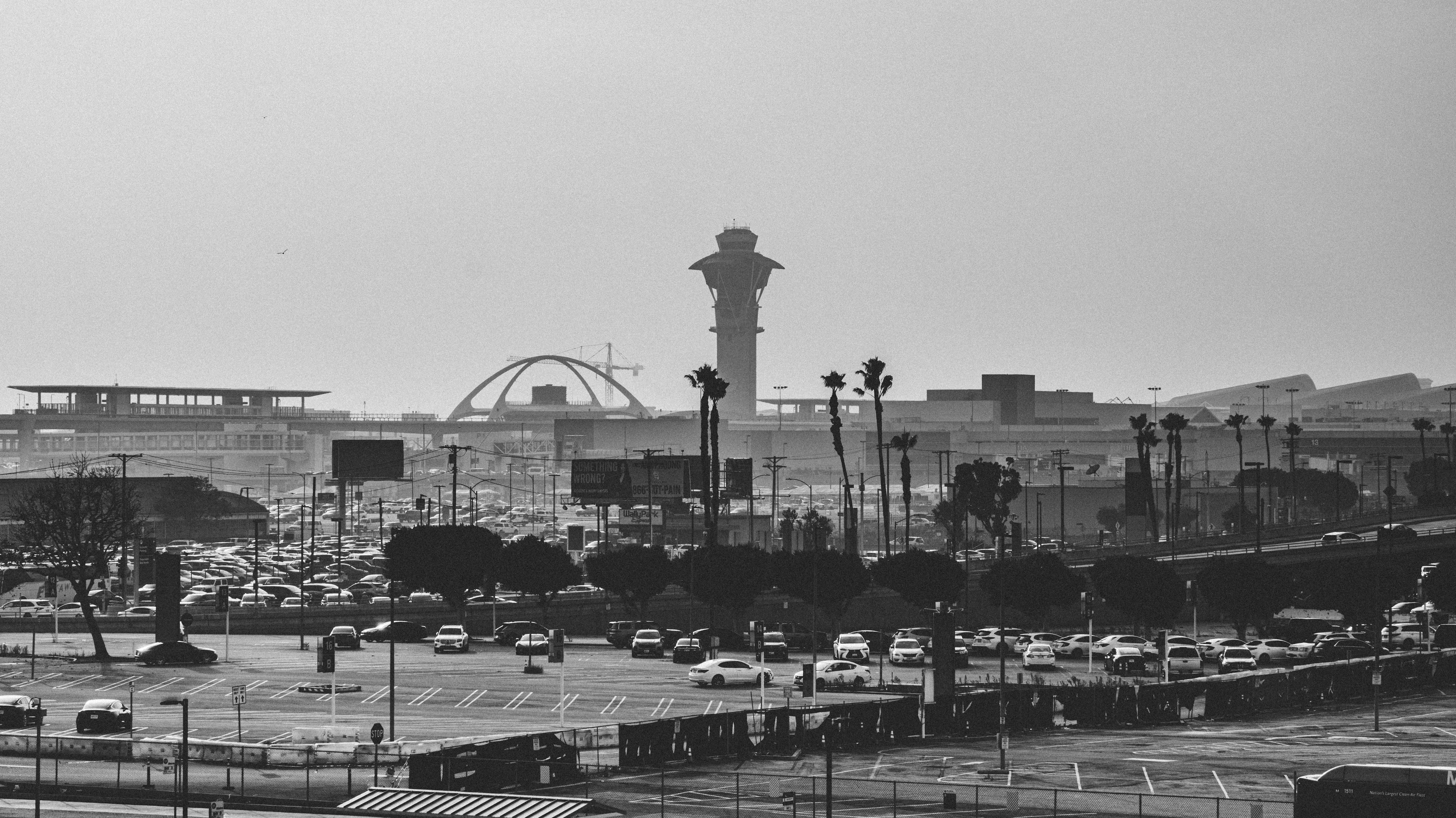 Toward the Terminal: A Parking Lot Framed by a Distant Control Tower