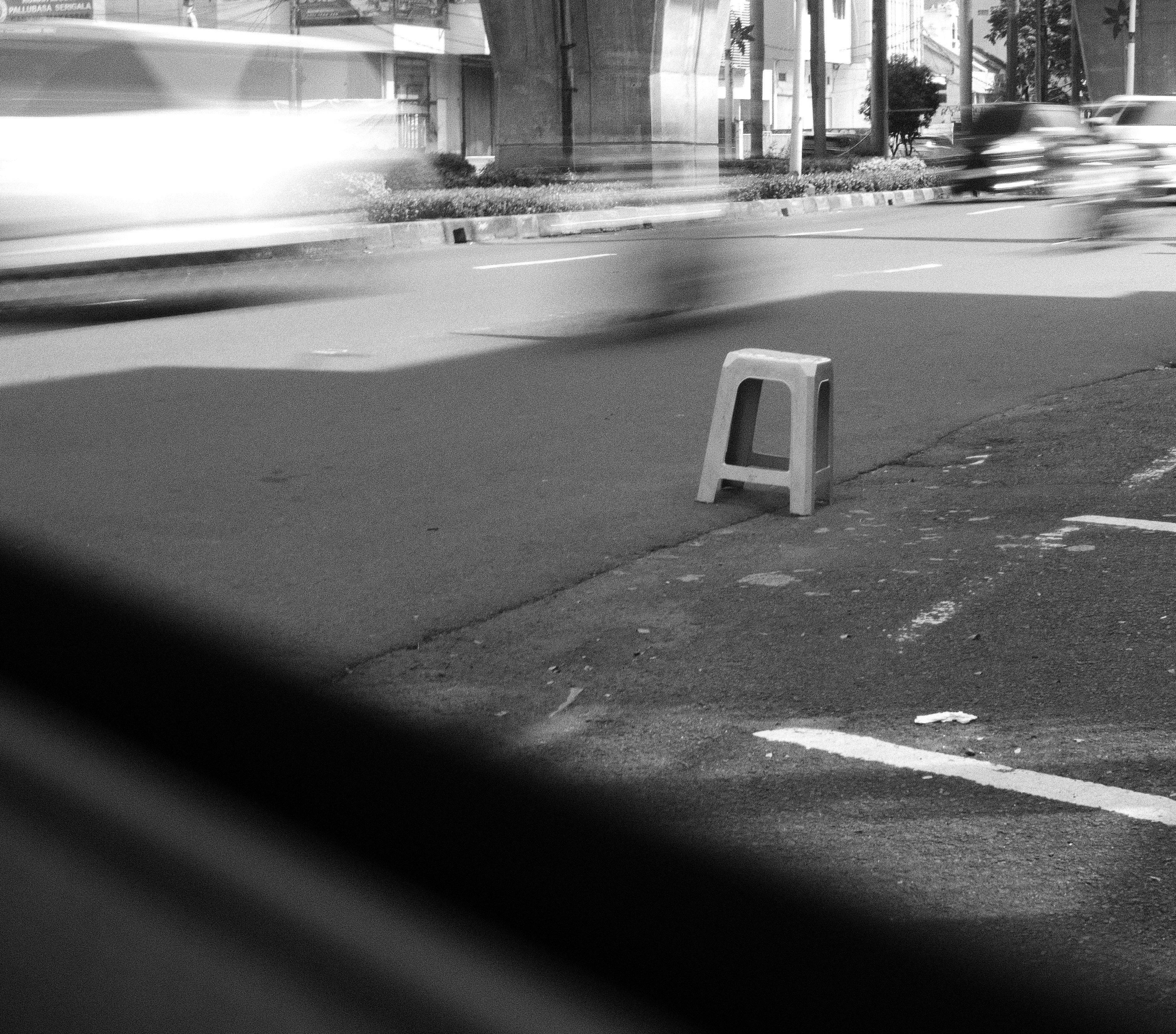 Urban Stool in Motion: A Quiet Moment on a Blurred Avenue