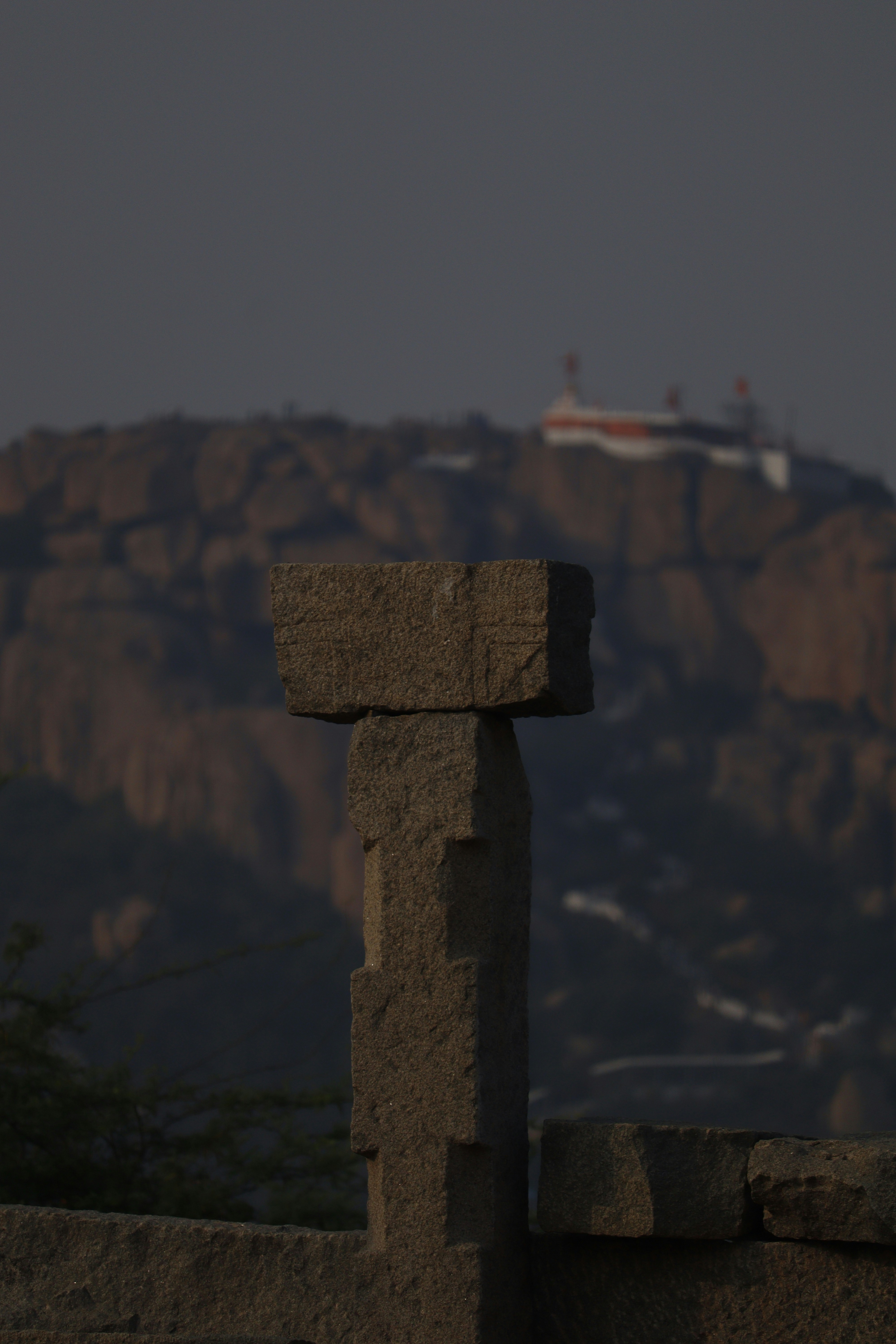 Stone Pillar in Quiet Dusk with Distant Clifftop Structure