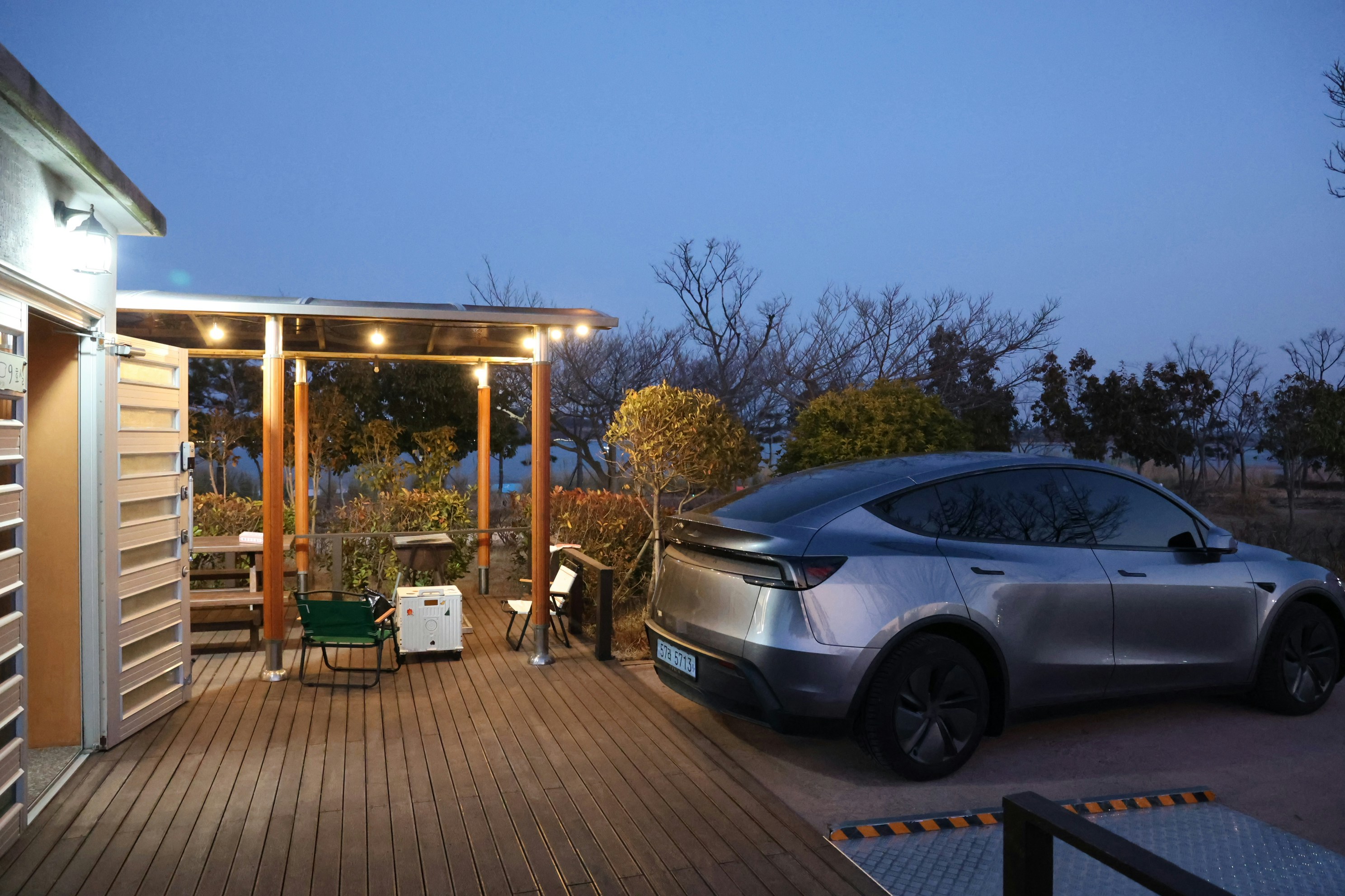 Evening Quiet by the Drive: A Silver EV by the Porch Lights