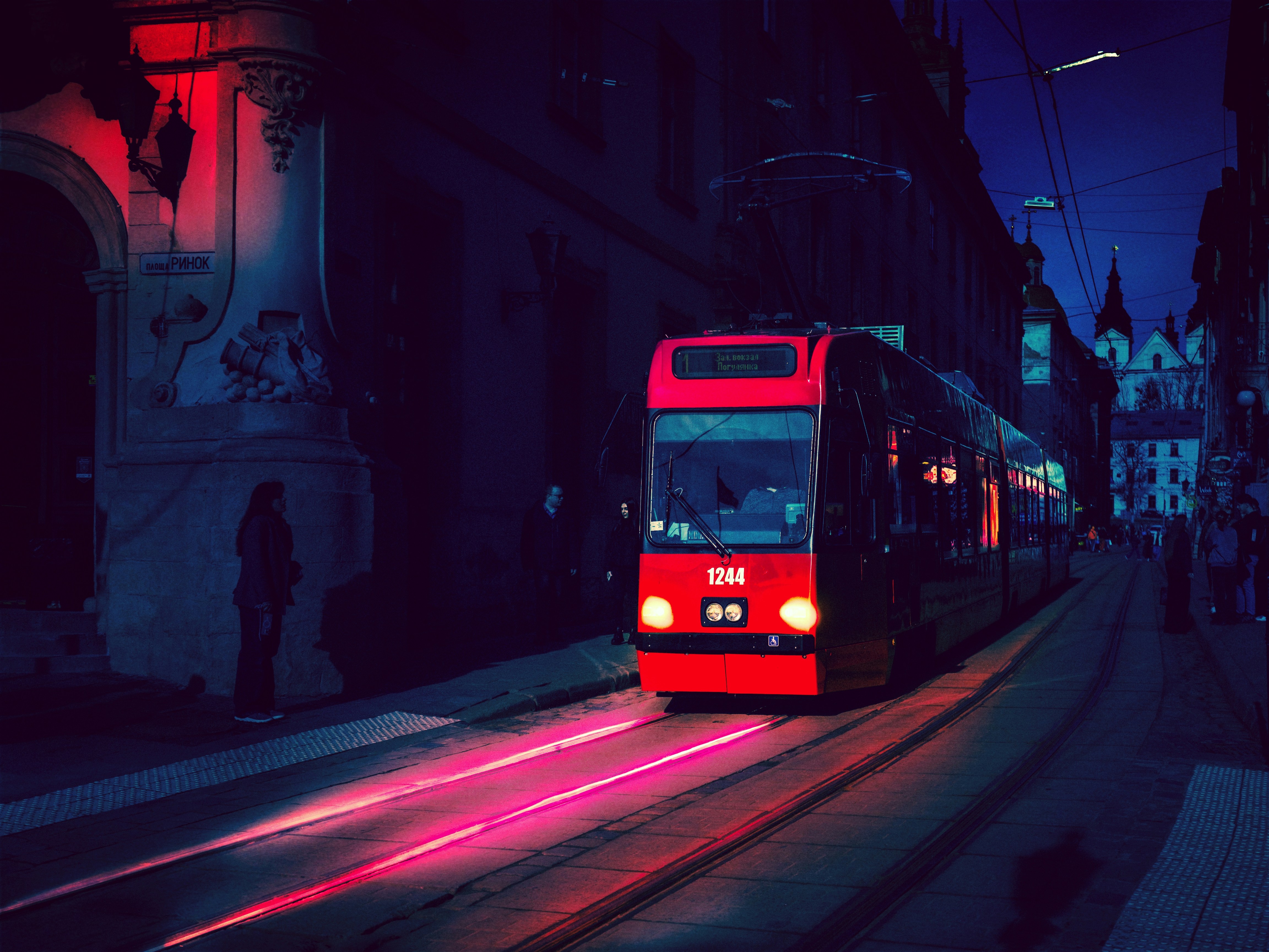 Red Tram Through Neon Night: A City Street in Motion