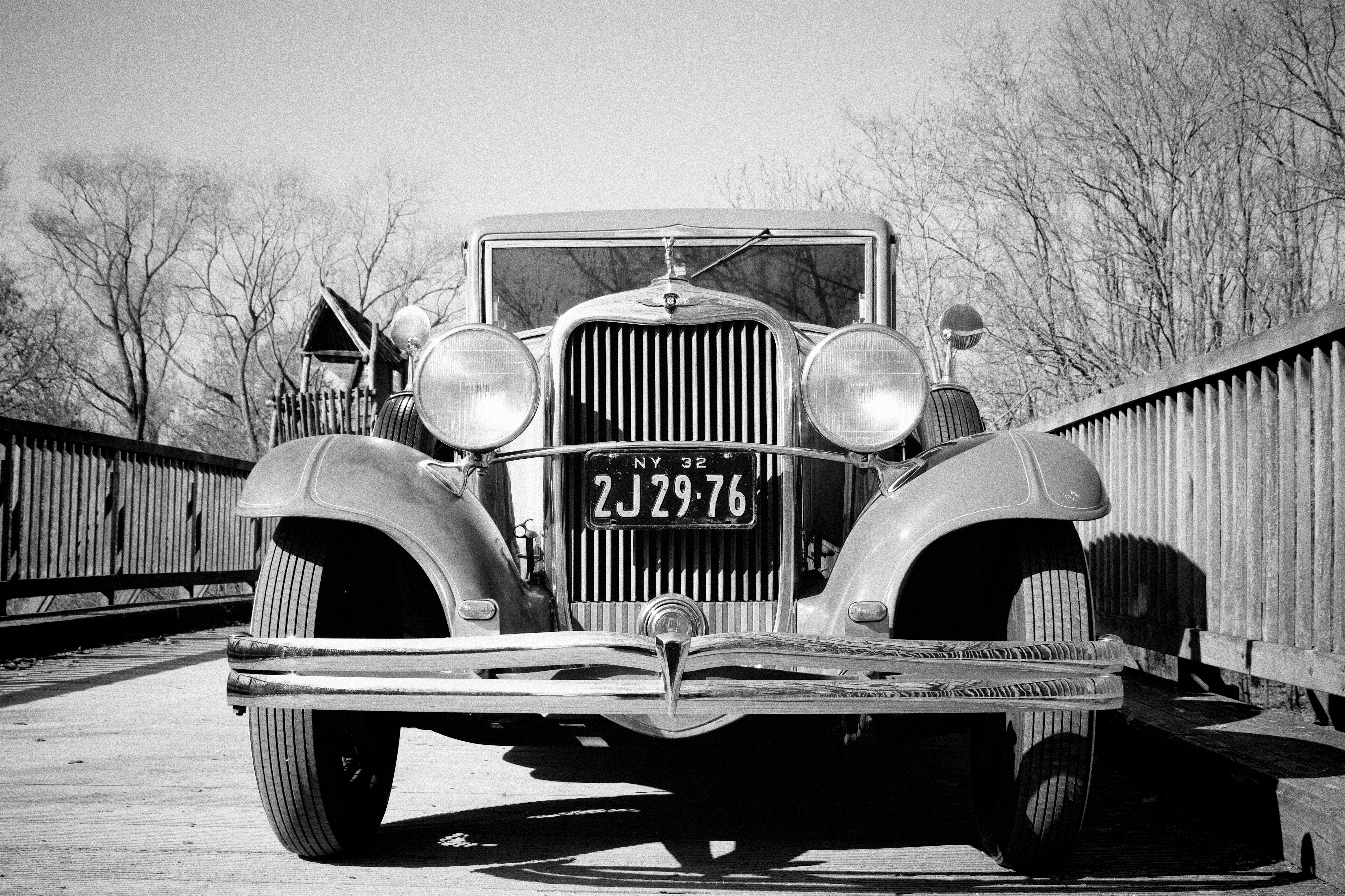 A Stoic Vintage Revival: Front View of an Antique Car on a Wooden Bridge