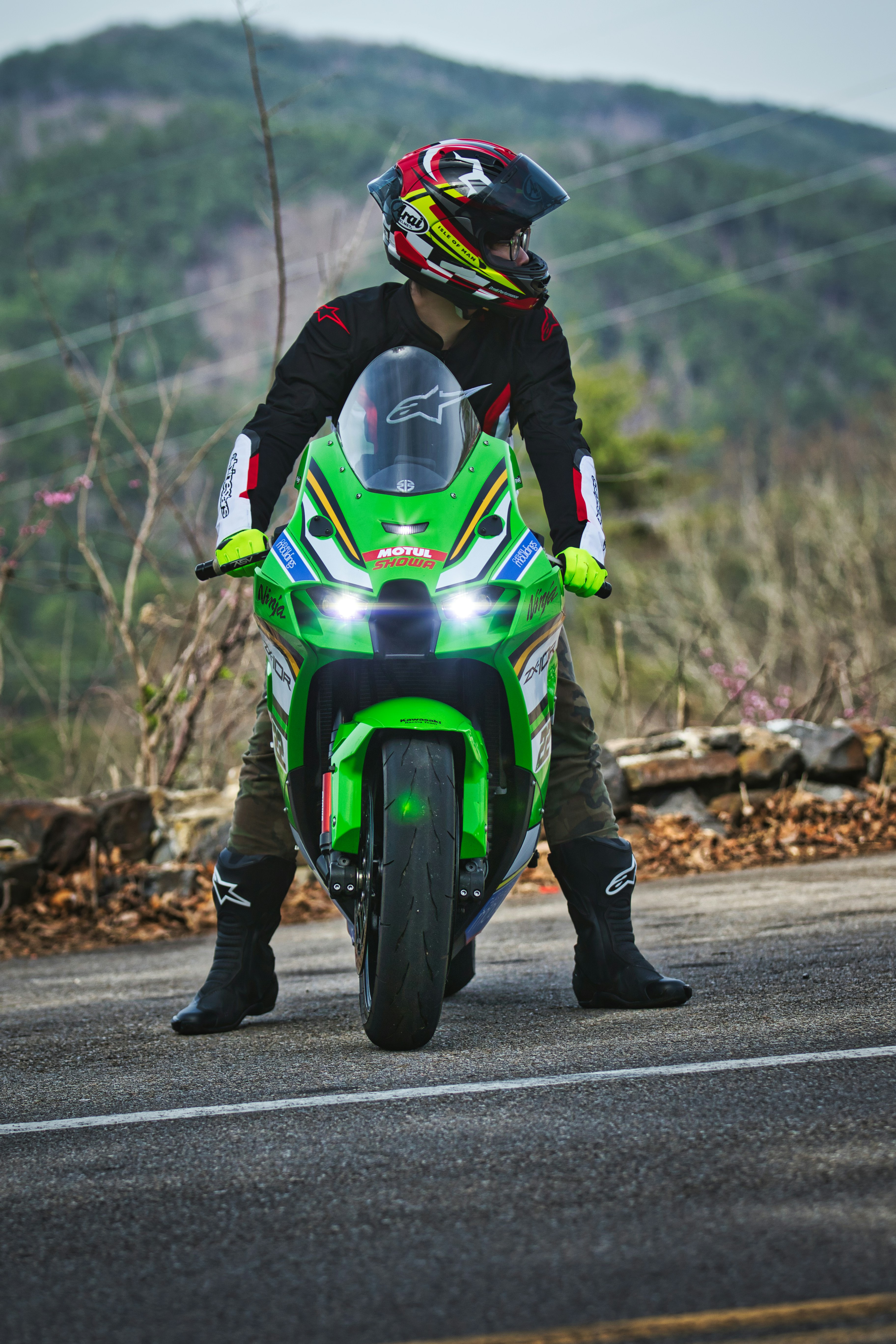 Green Machine: Motorcyclist in Neon Gear Ready on a Mountain Road