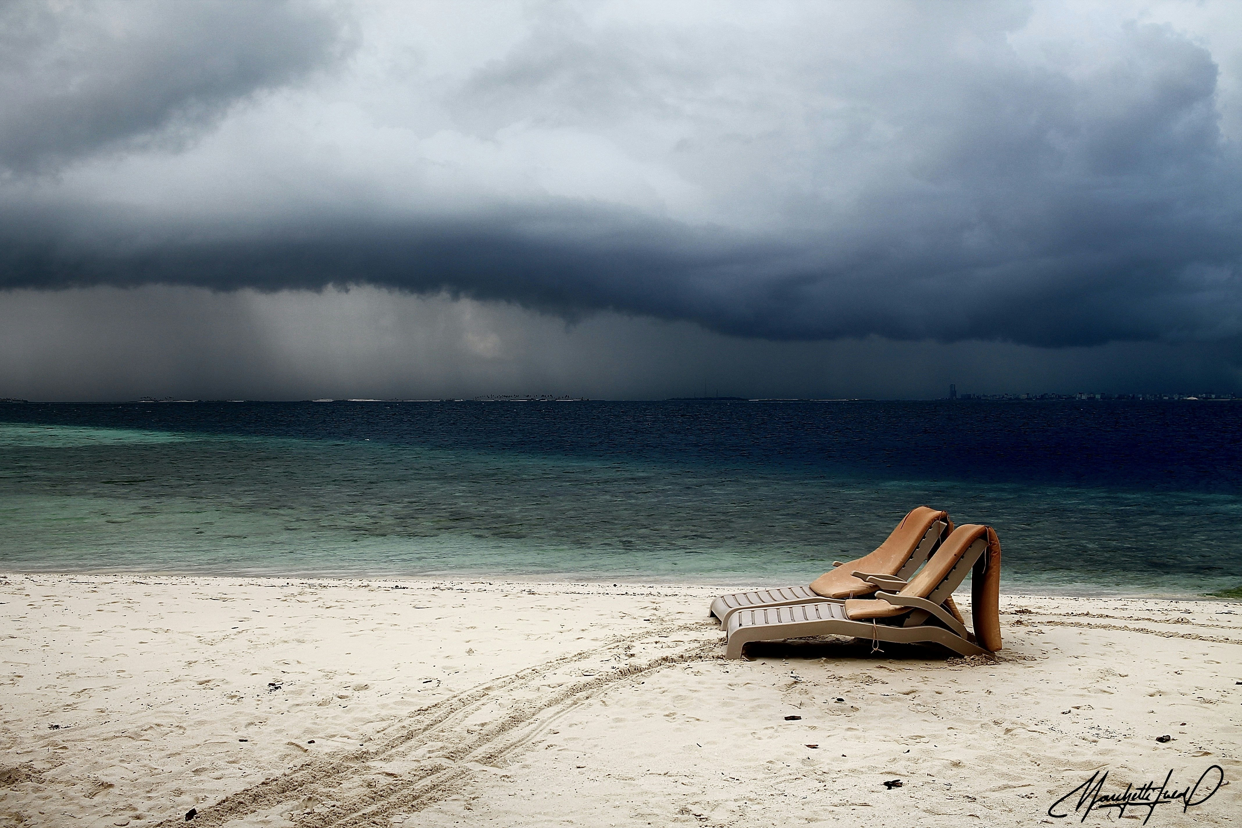 Deserted Beach Chairs Under A Thunderous Sky
