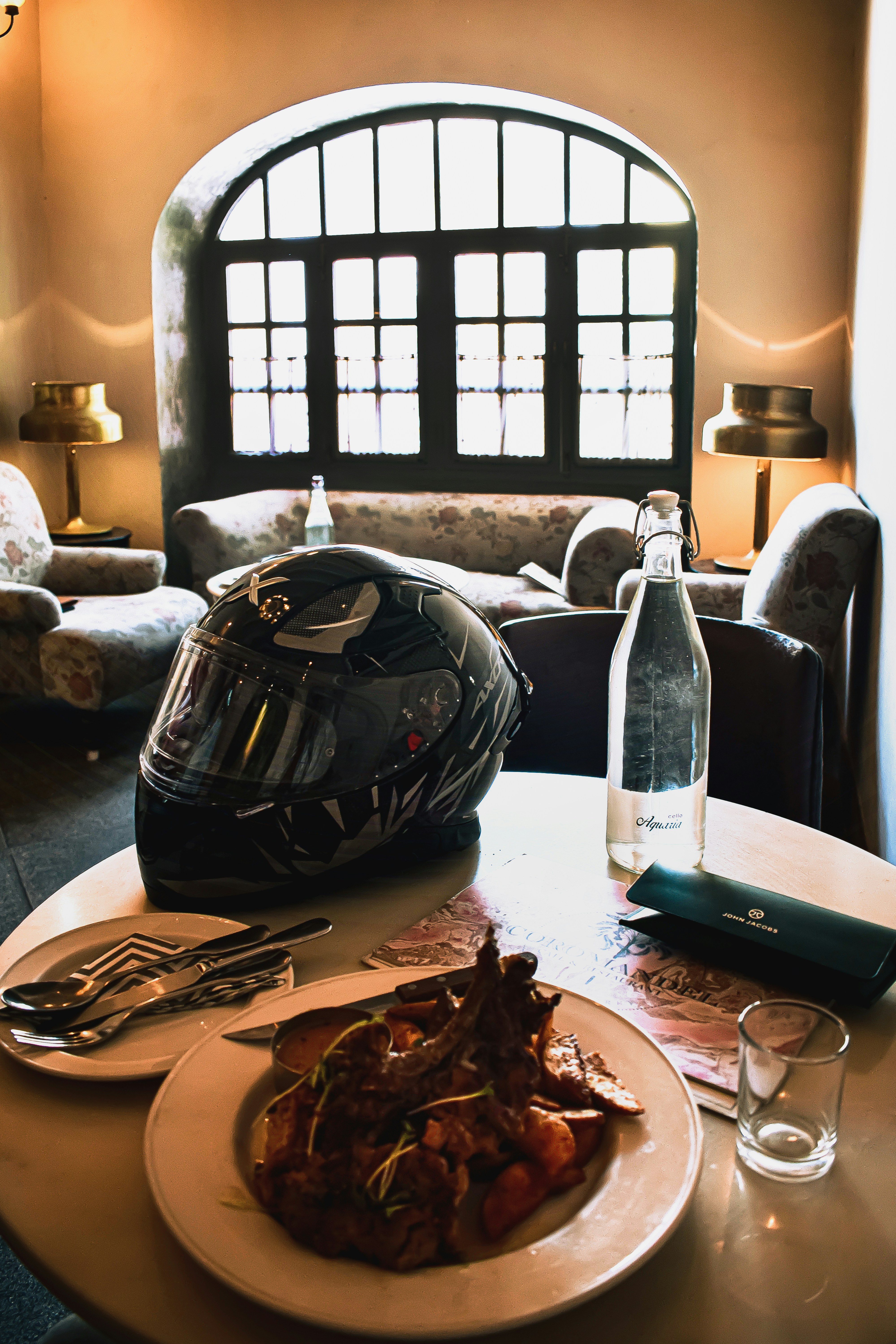 A Quiet Café Moment: Helmet on the Table by a Sunlit Window
