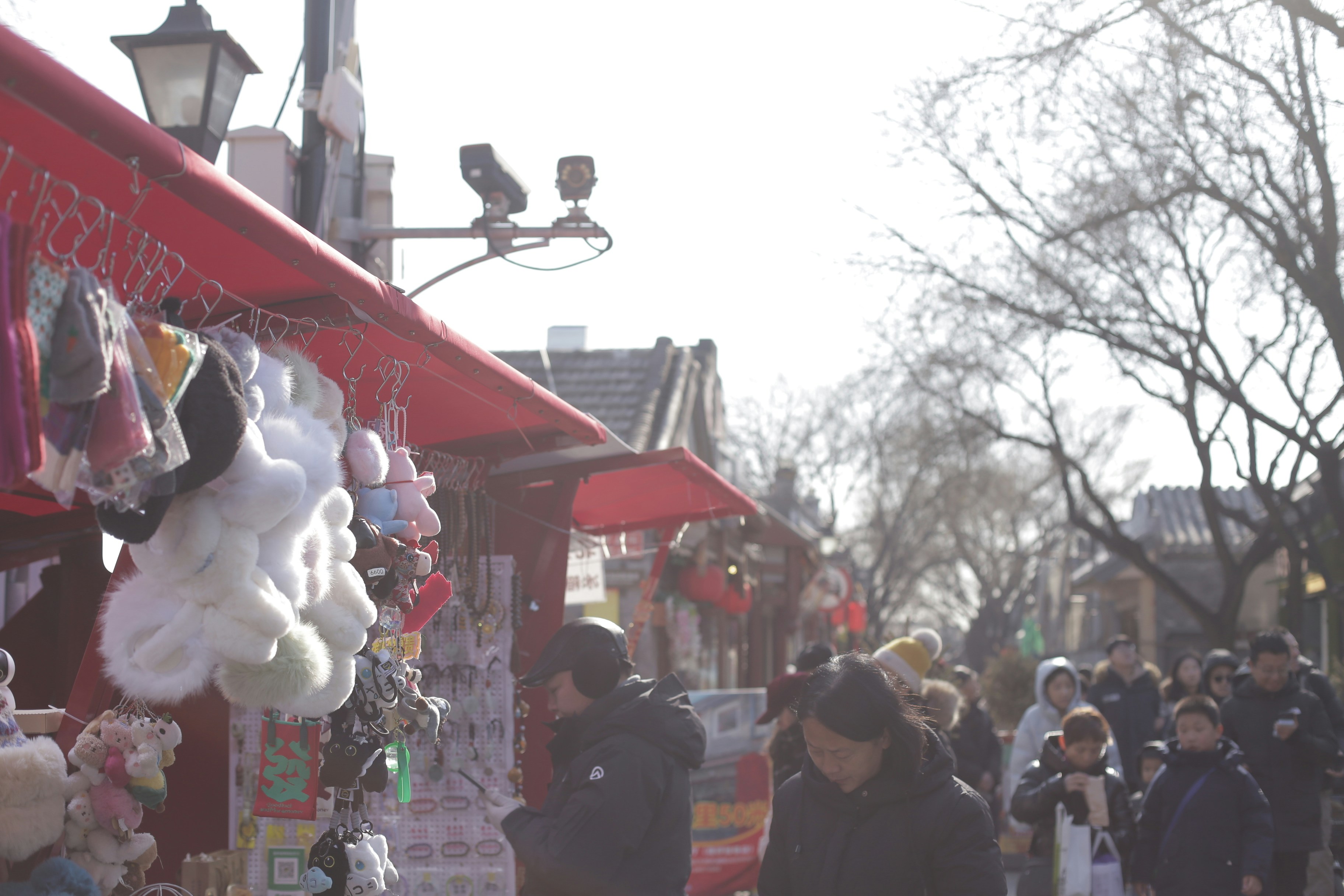 Market Stalls Under Red Canopies: A Quiet Winter Crowd