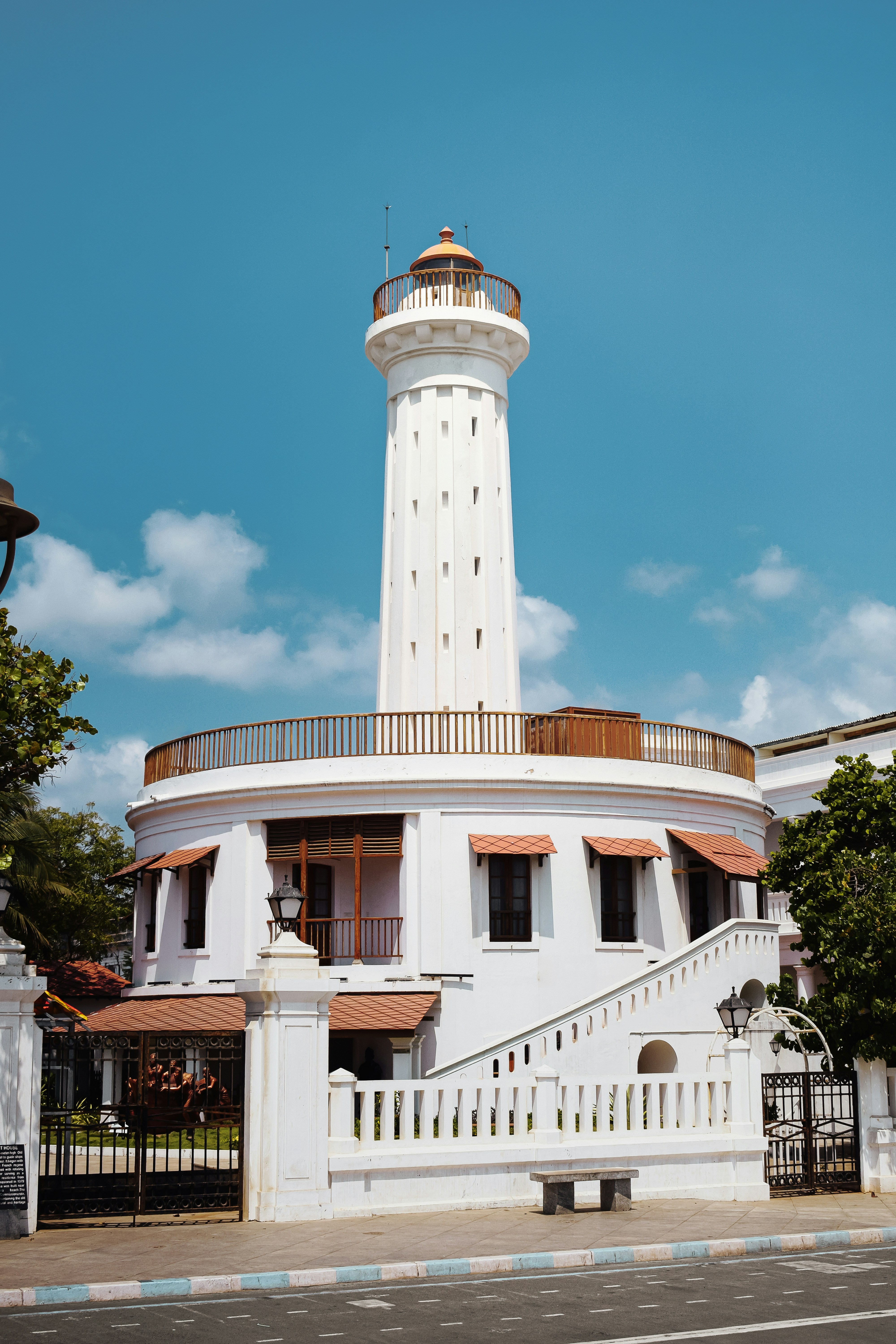  beacon over white fortress: a coastal lighthouse rising above pastel terraces