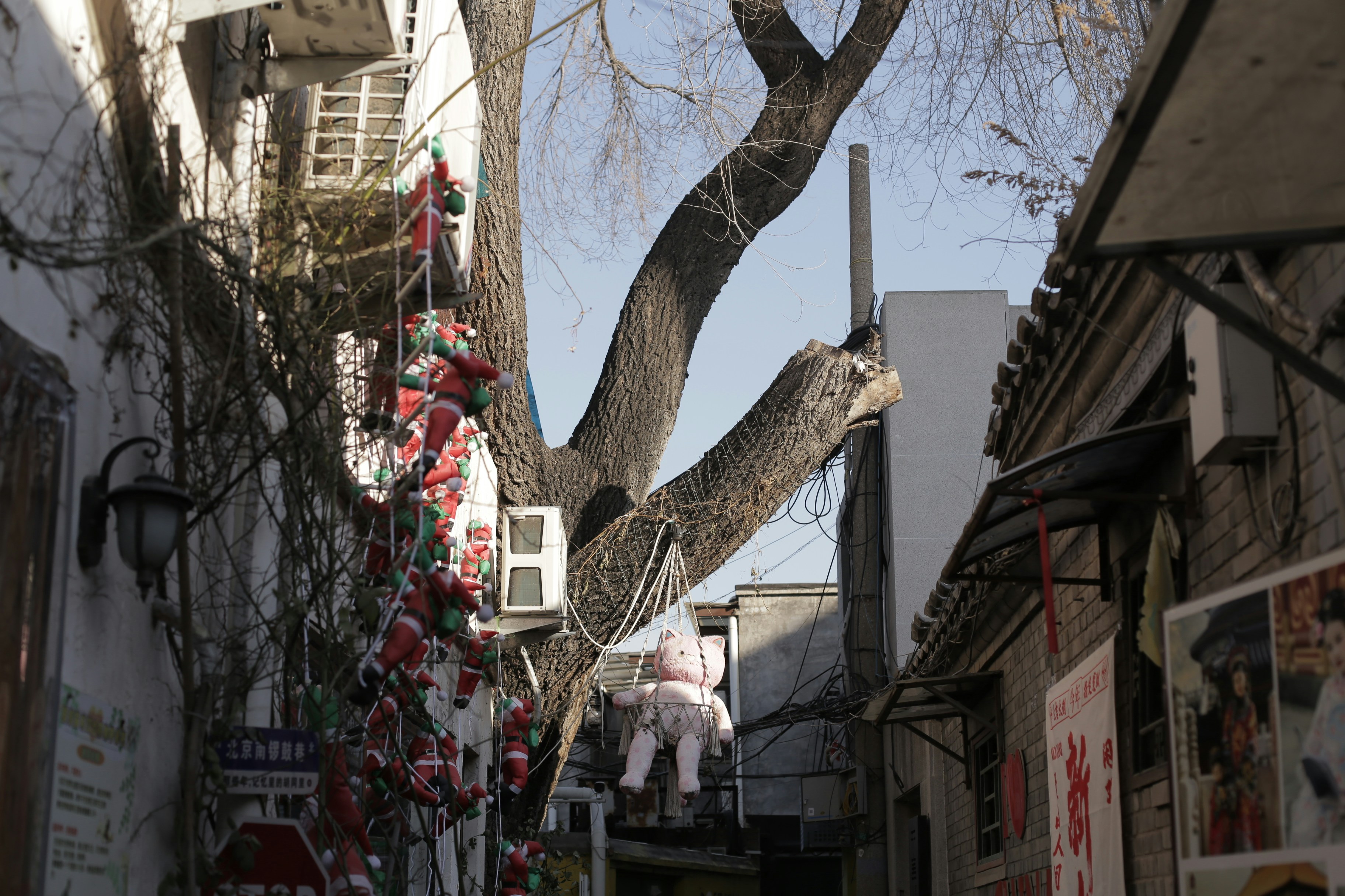 Laddered lanterns and festive toys along a sunlit alley