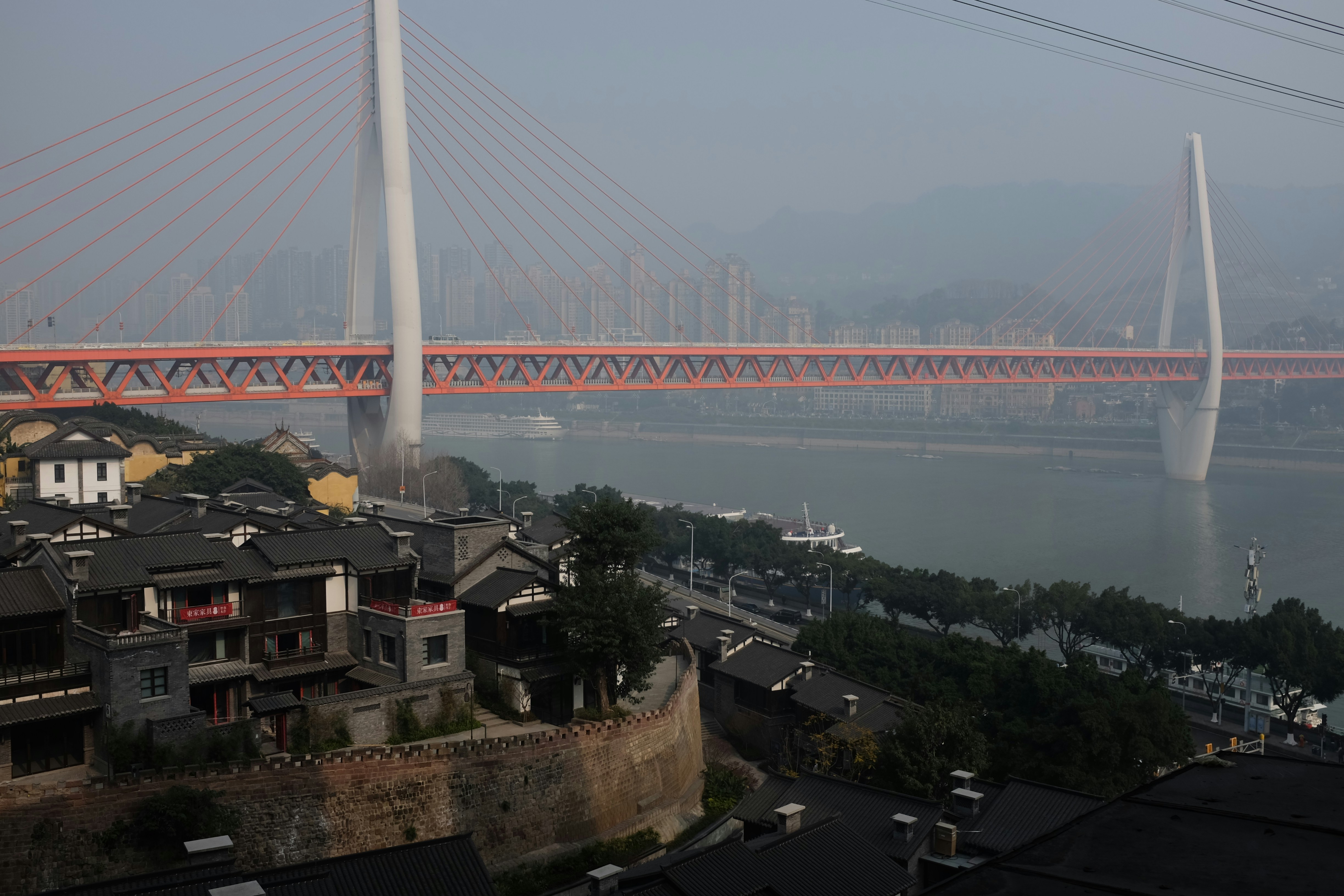 Suspended Grace: A City by the River with a Red-Hued Bridge