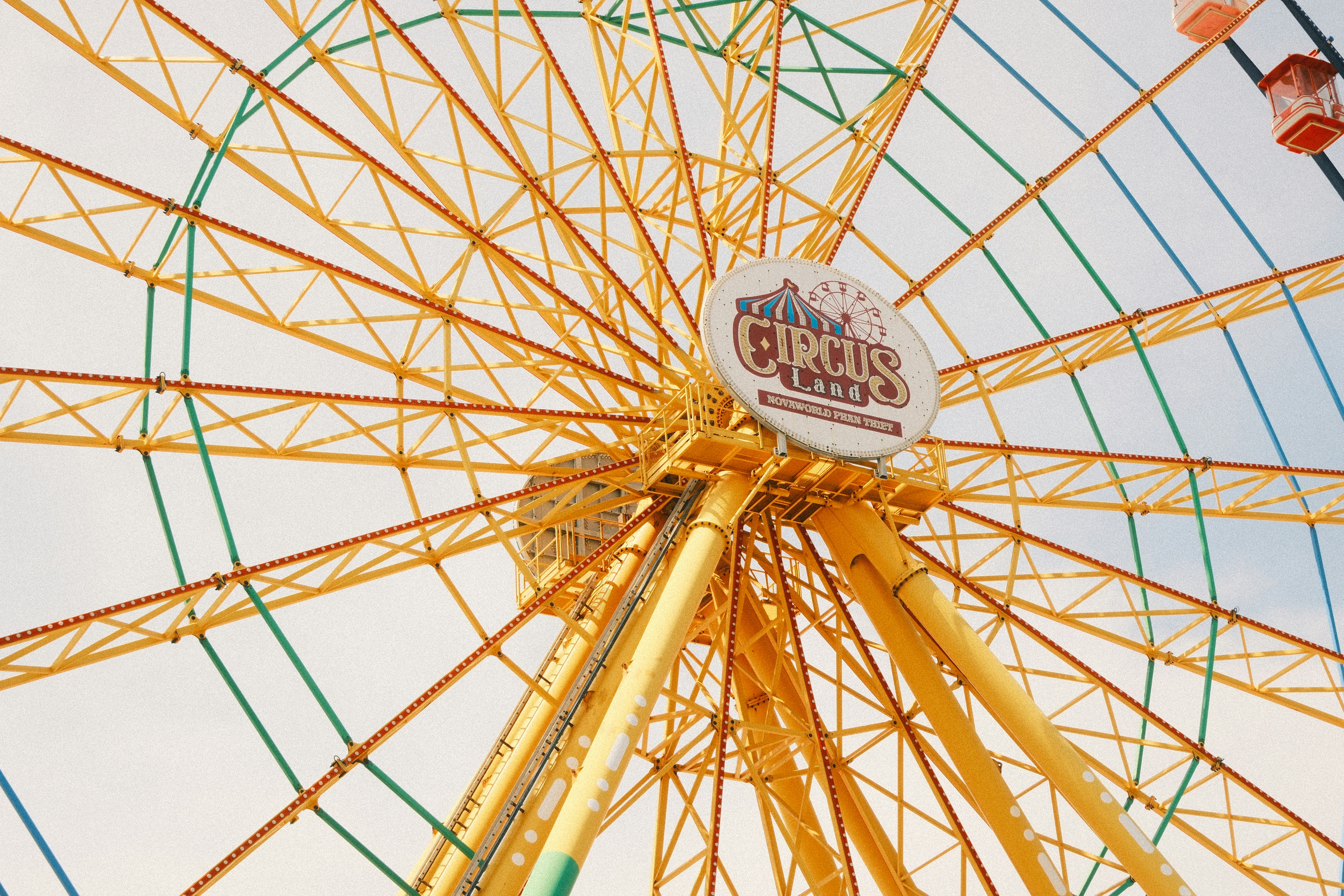 Spoked Sunrise: A Close-Up of a Circus Ferris Wheel Cresting the Sky