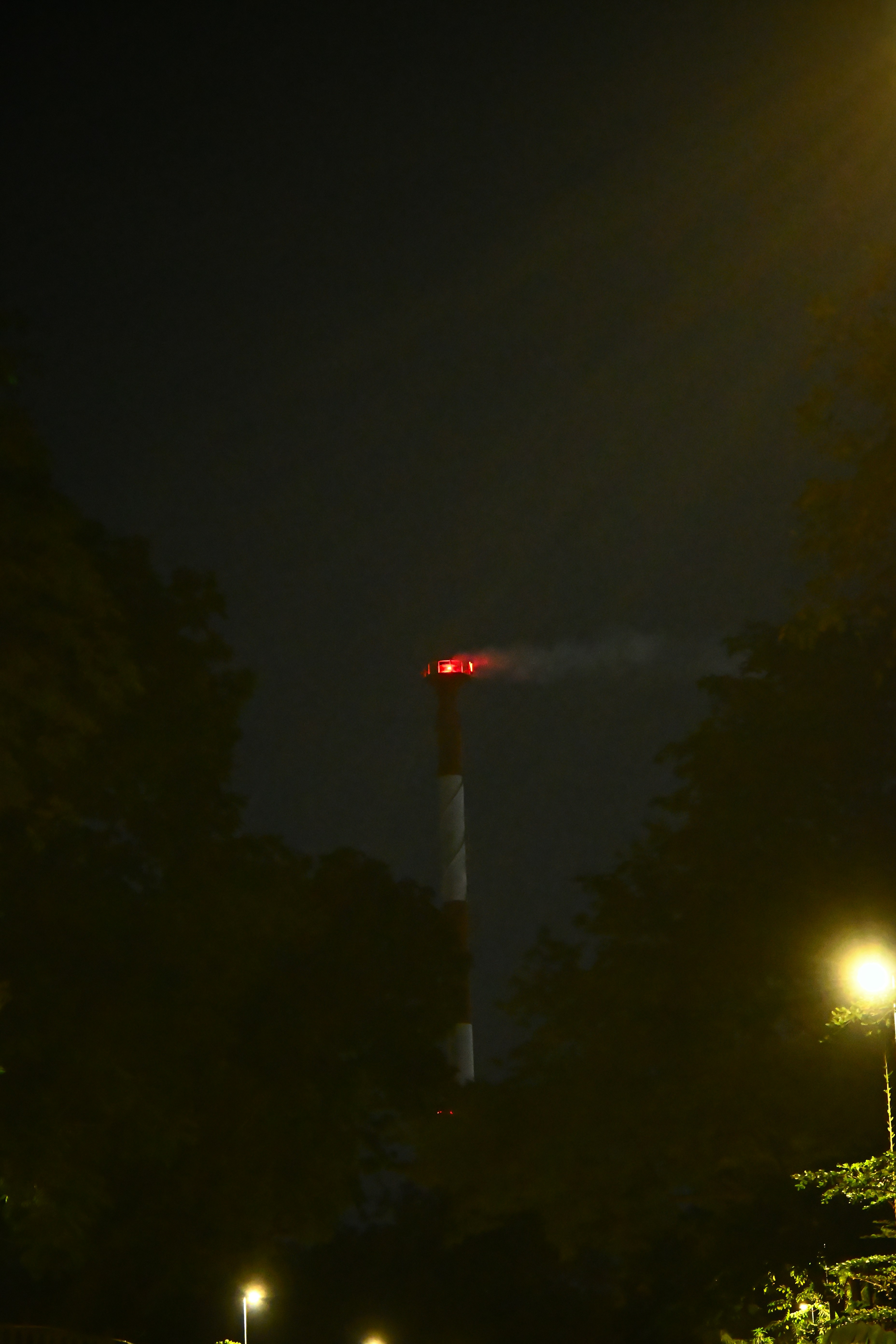 Night Industrial Beacon: A Red Eye in the Chimney Mist