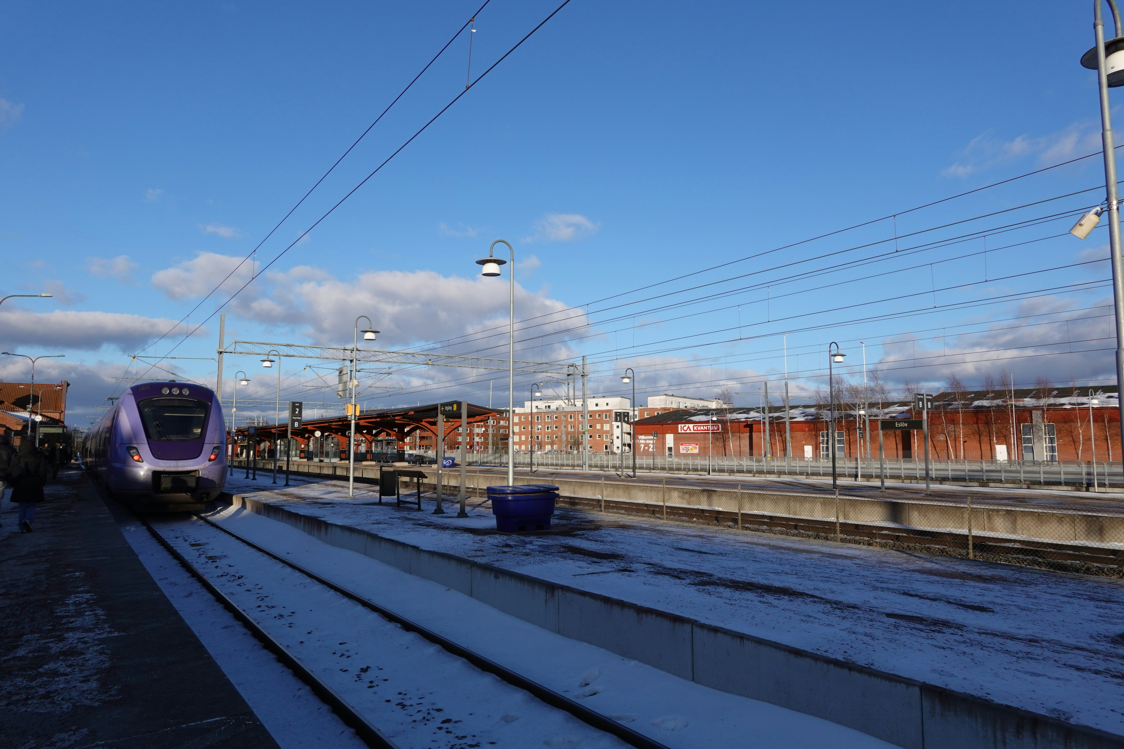 Purple loco at edge of winter platform under a crisp blue sky