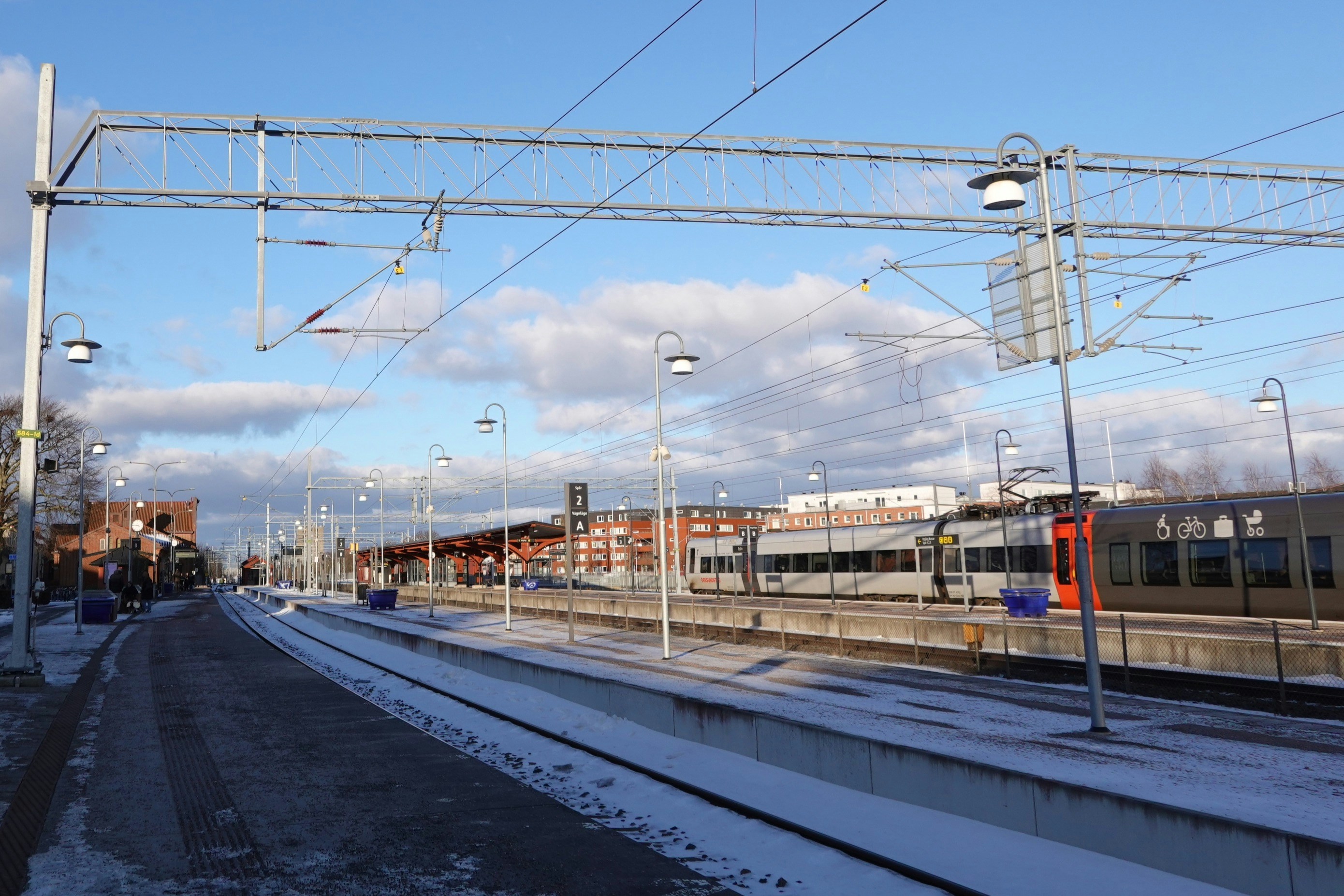 Sunlit Platform Echoes: A Snow-Kissed Rail Yard Under Clear Skies
