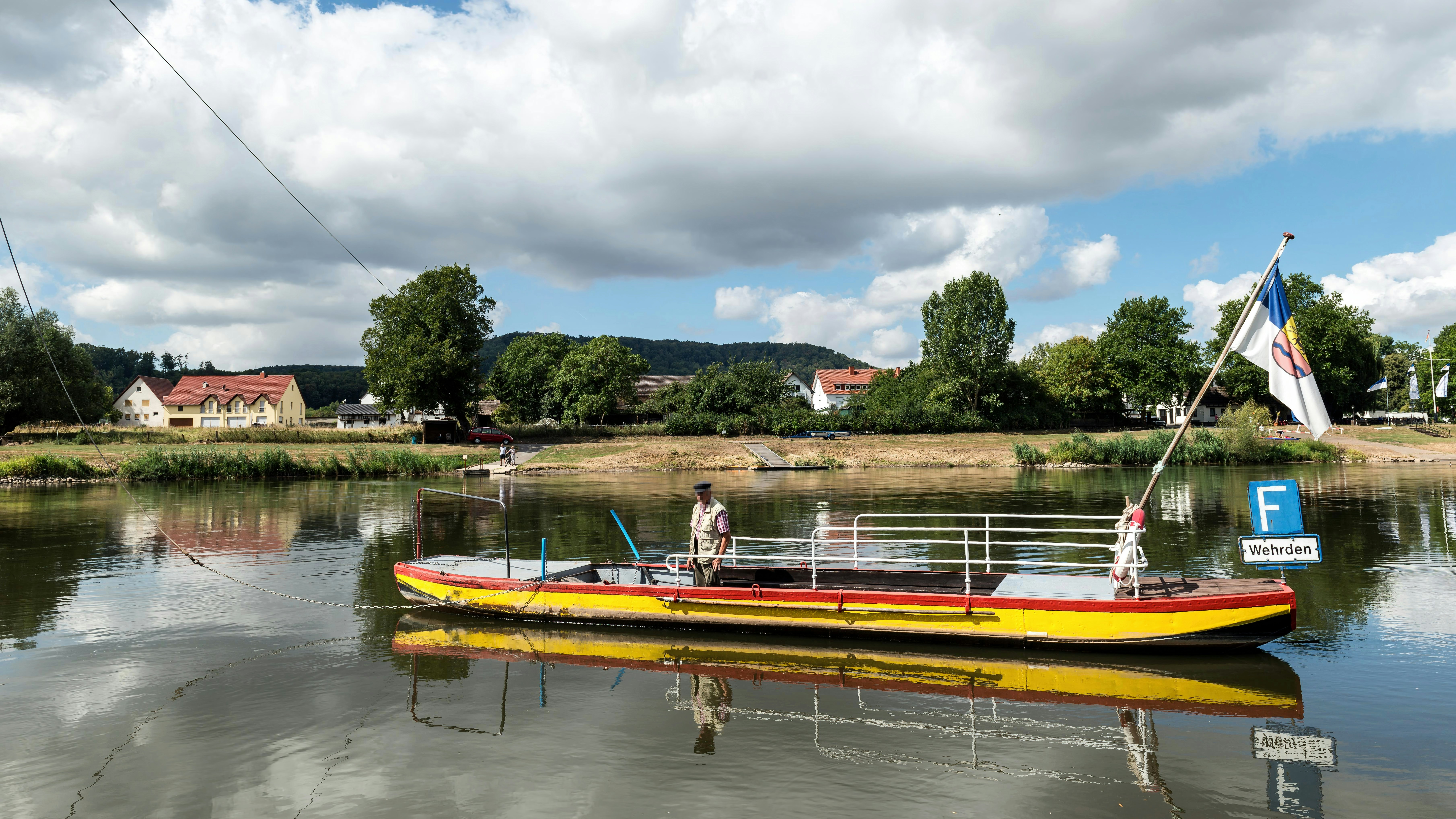 Colorful riverboat gliding past a calm lakeside village