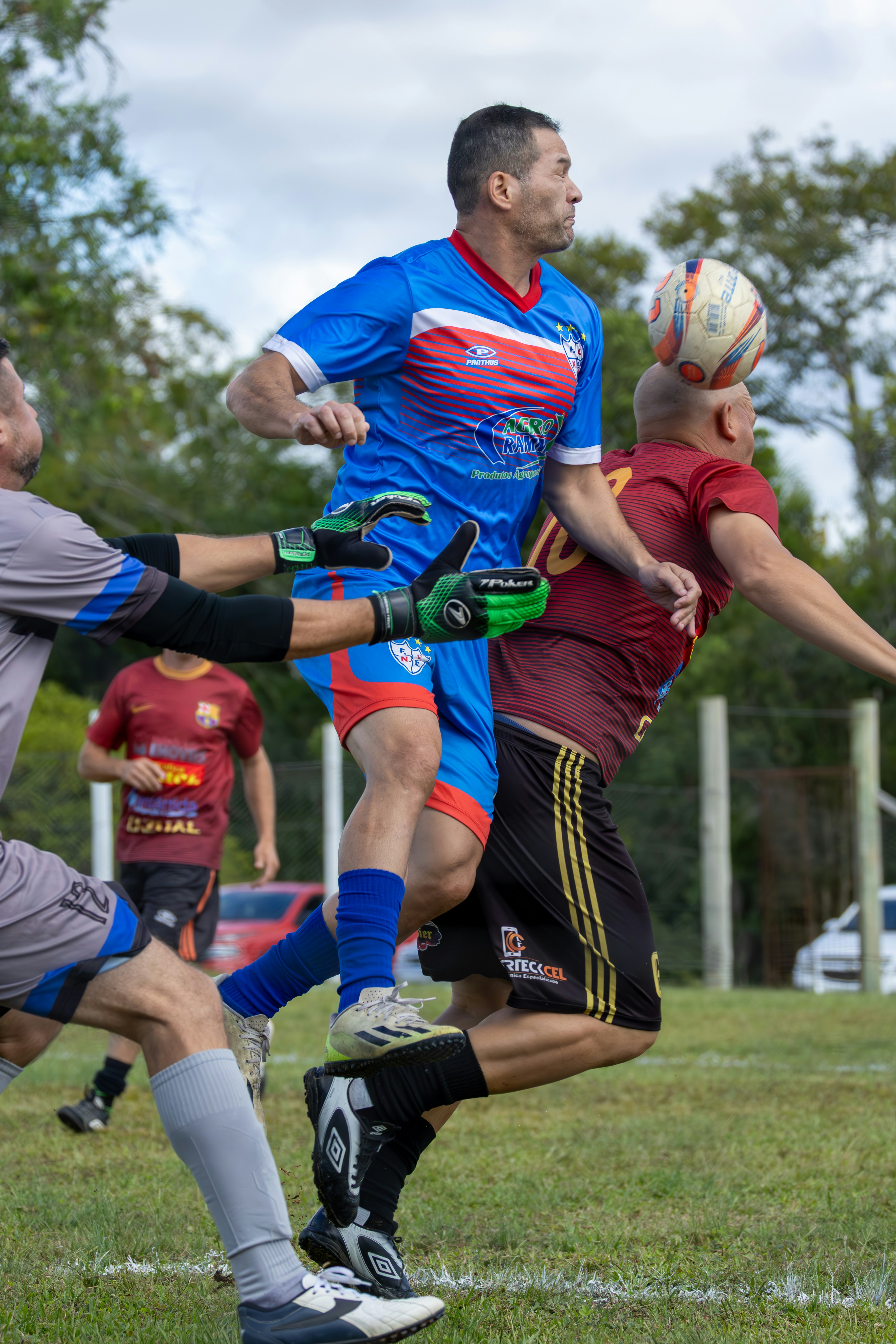 Midair Challenge: A Shielded Striker in Blue Surges Toward the Ball