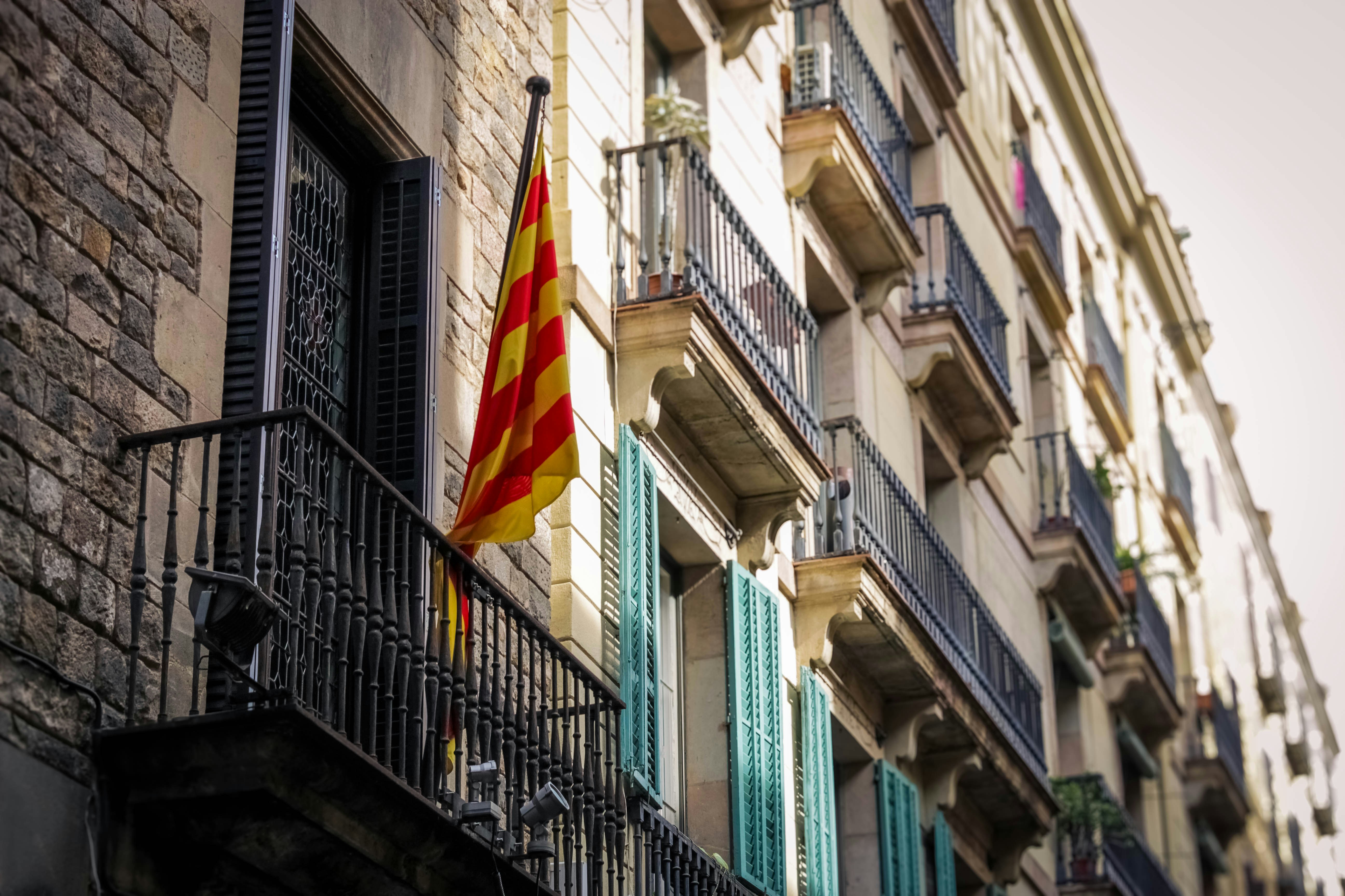 Flag on a Balcony: Catalan Colors Drape the Facade