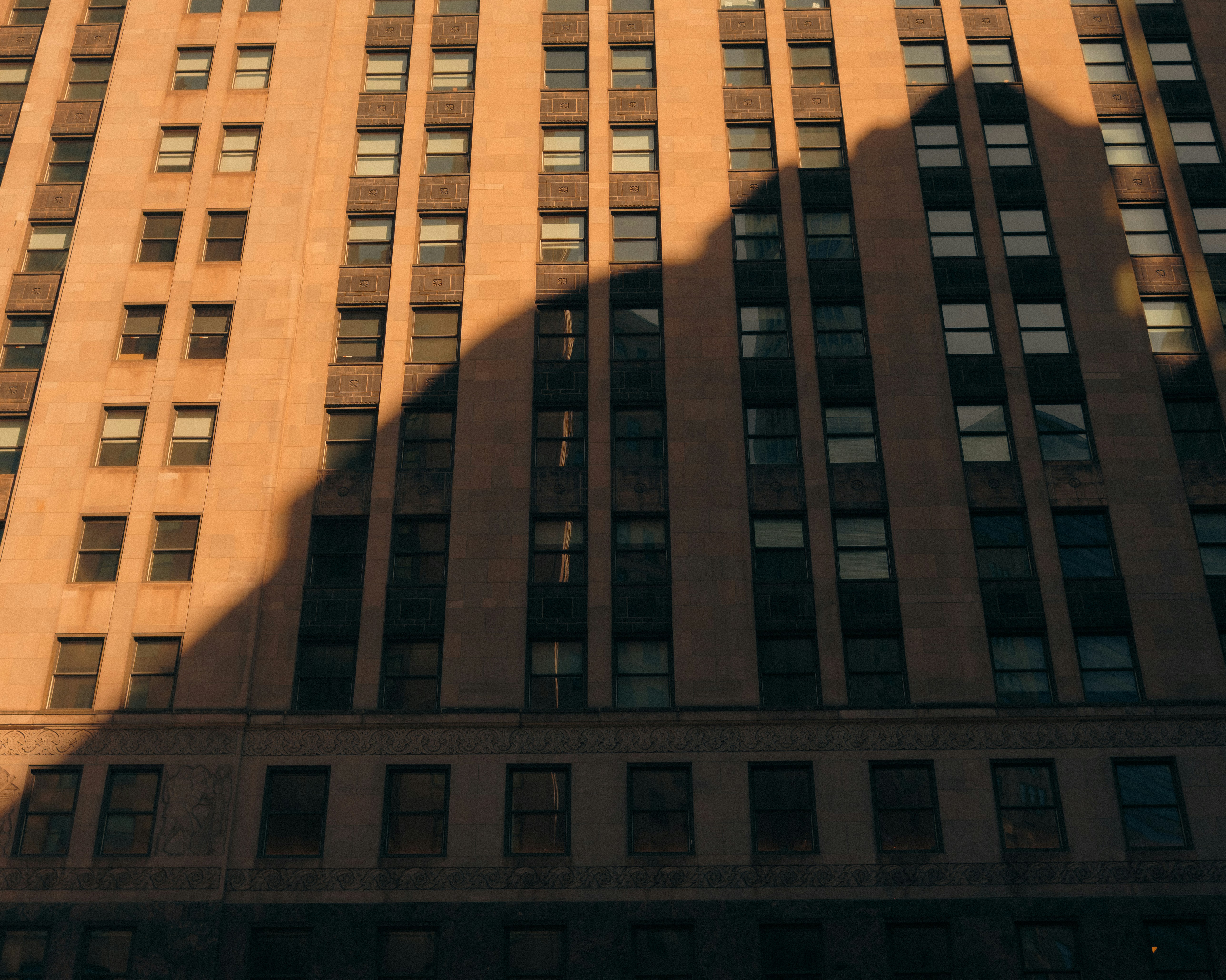 Shadowed Skyscraper: Late Day Geometry Casting a Bold Diagonal Over Facade