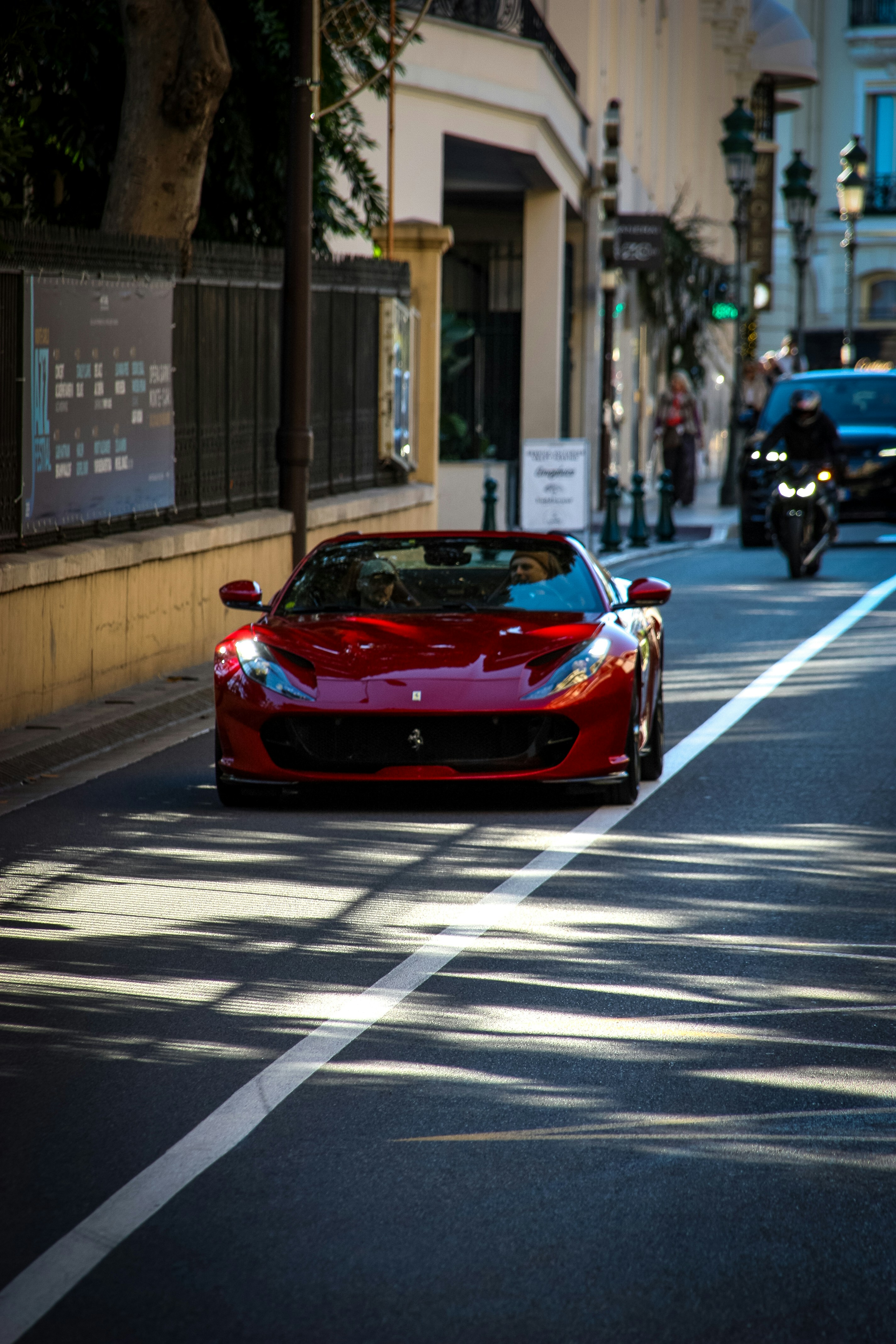Red Ferrari on a Sunlit City Street
