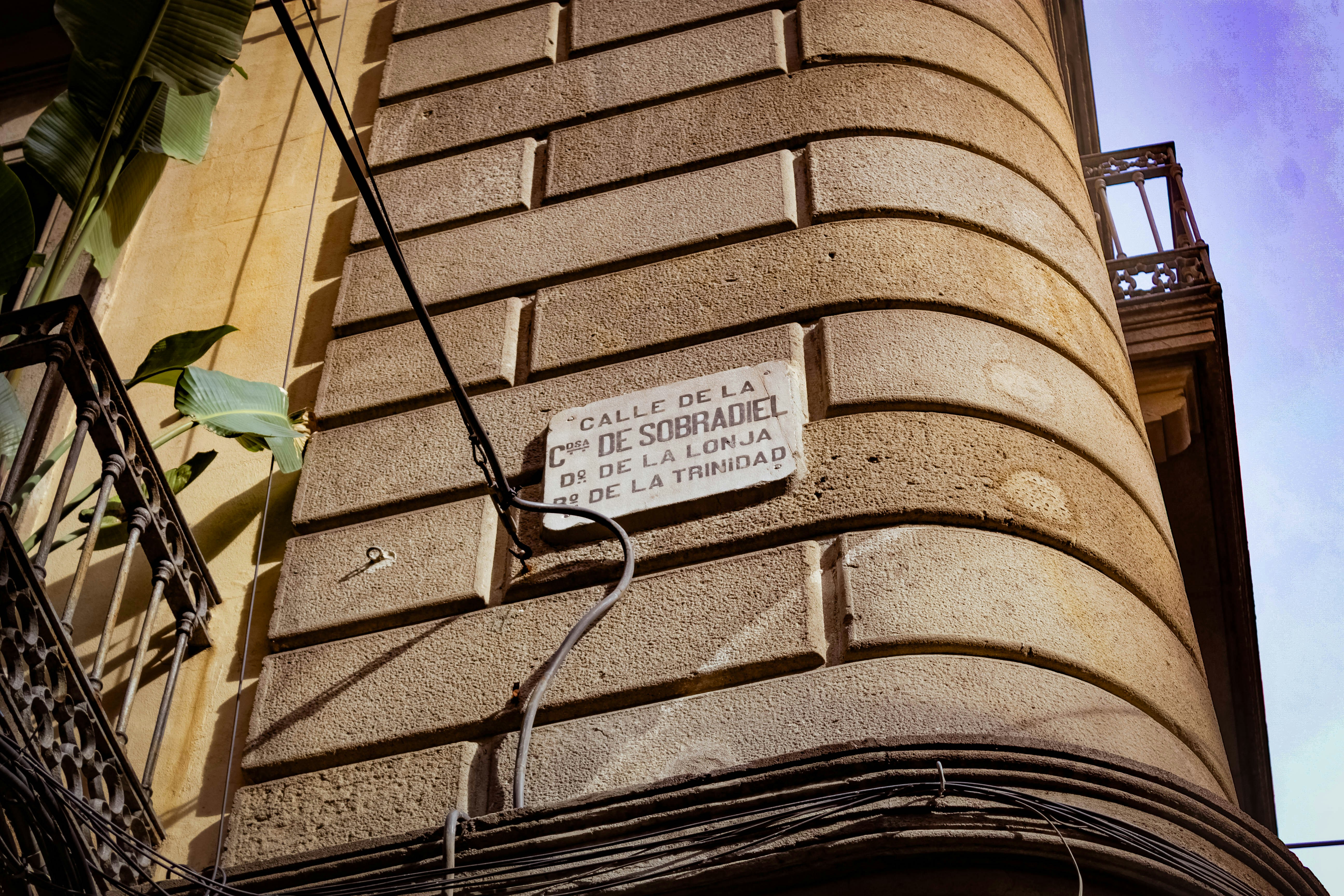 Curved Cornerstones and a Street Sign on a Weathered Barcelona Block