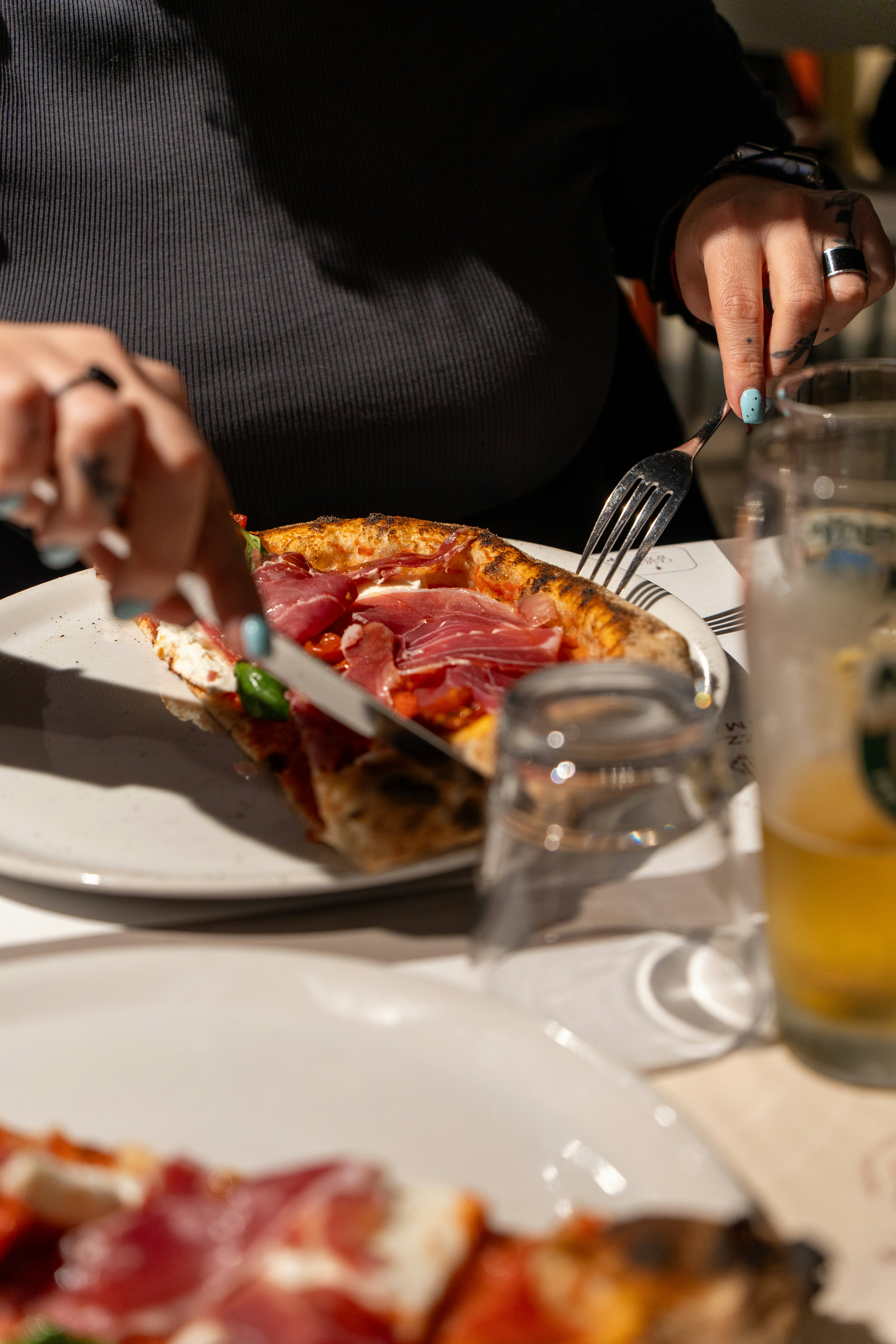 Hands at the Table: Slices of Pepperoni and Focused Flavor