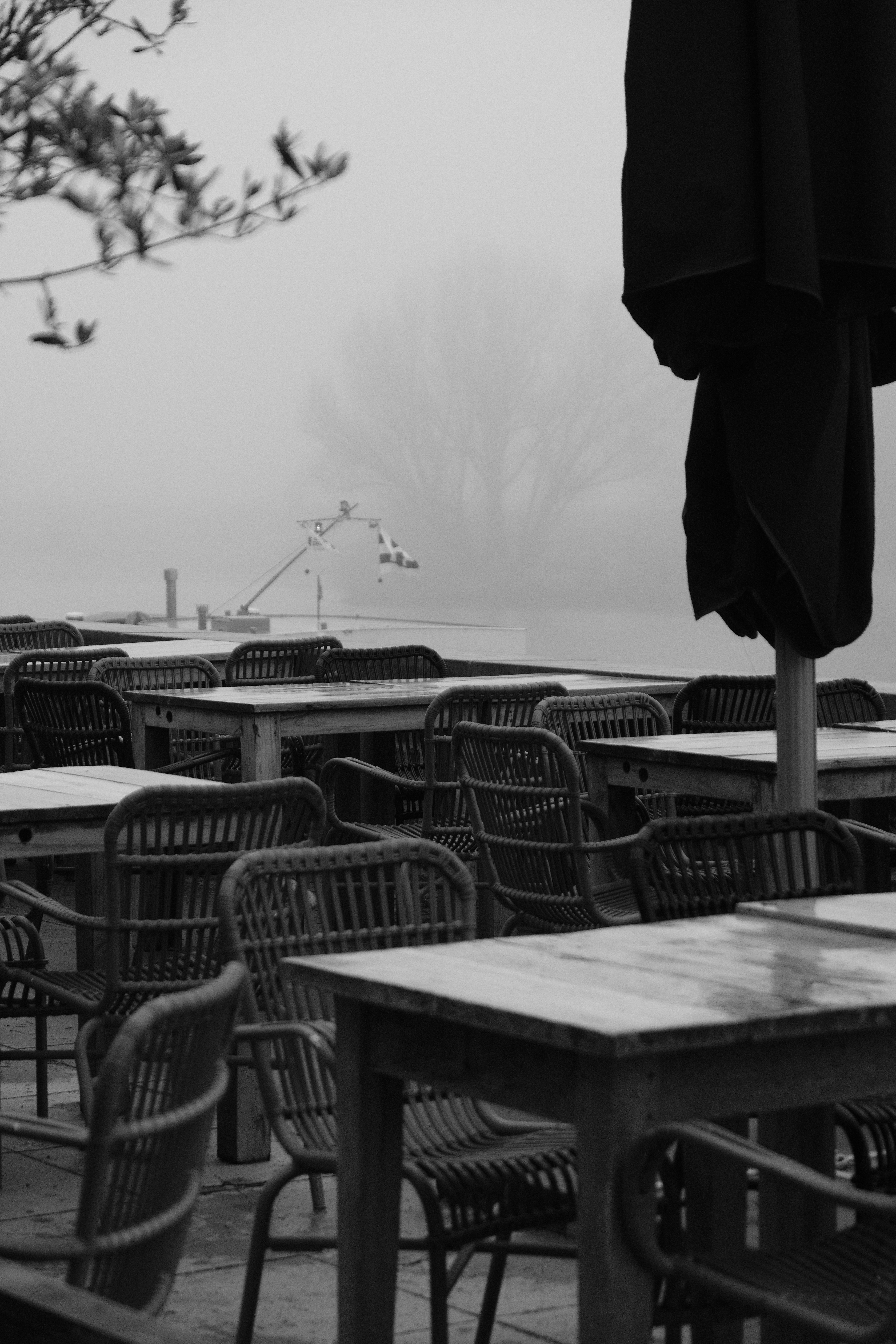 Quiet Terrace Beneath the Mist: Empty Tables and Veiled Harbour
