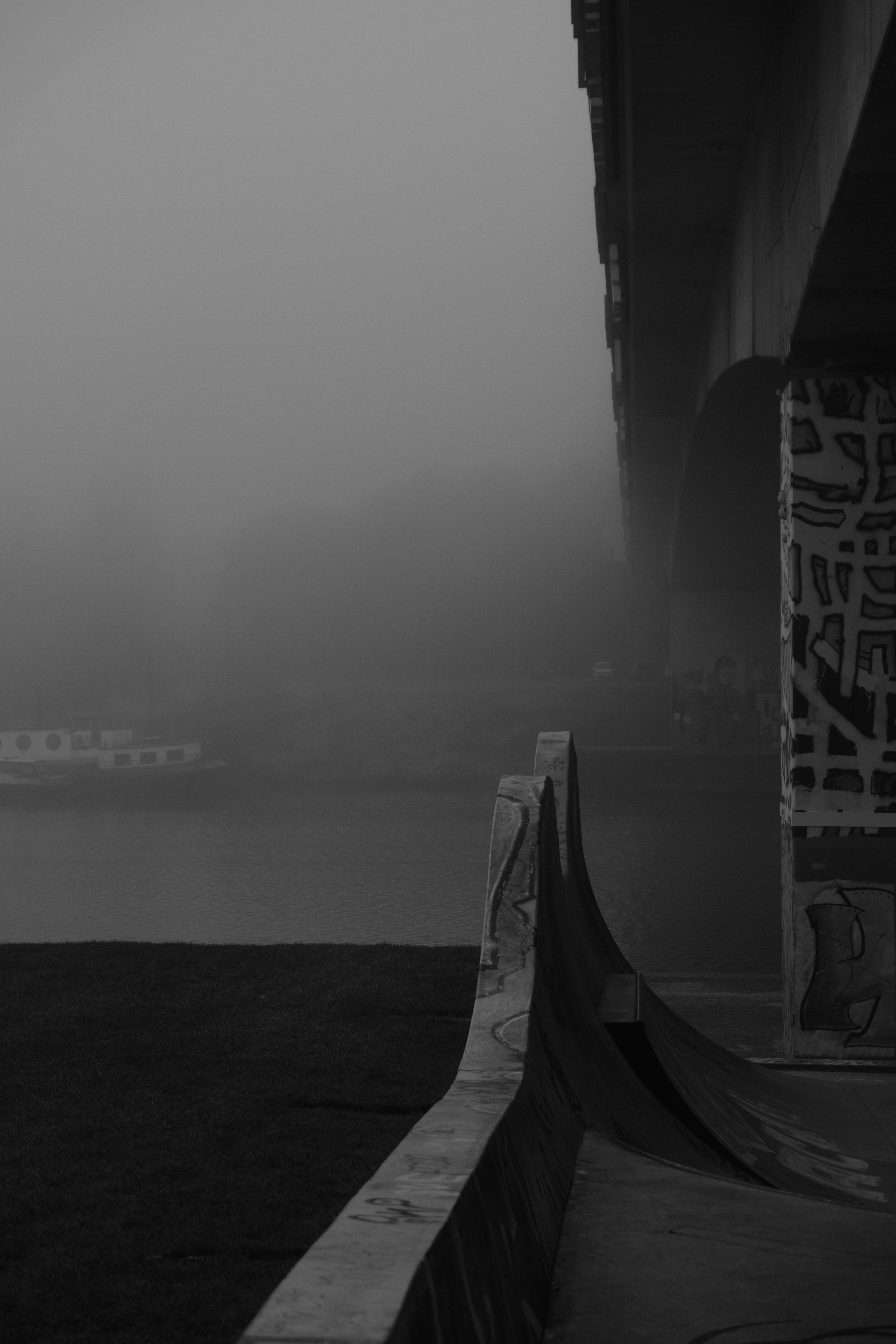 Concrete Shoreline: A Fog-Choked Moment Under the Bridge