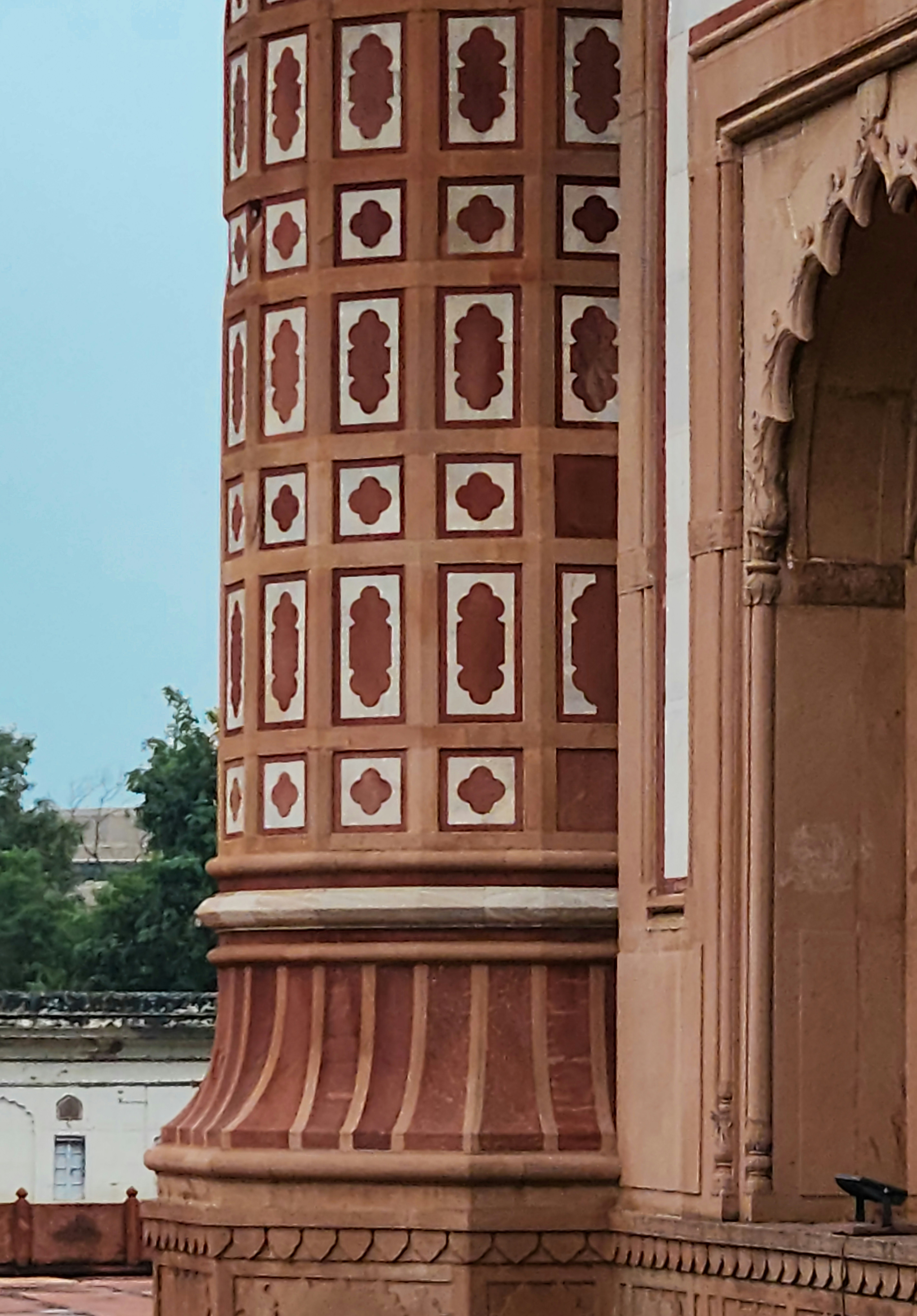 Red Sandstone Facade: Columned Geometry and Ornate Archway