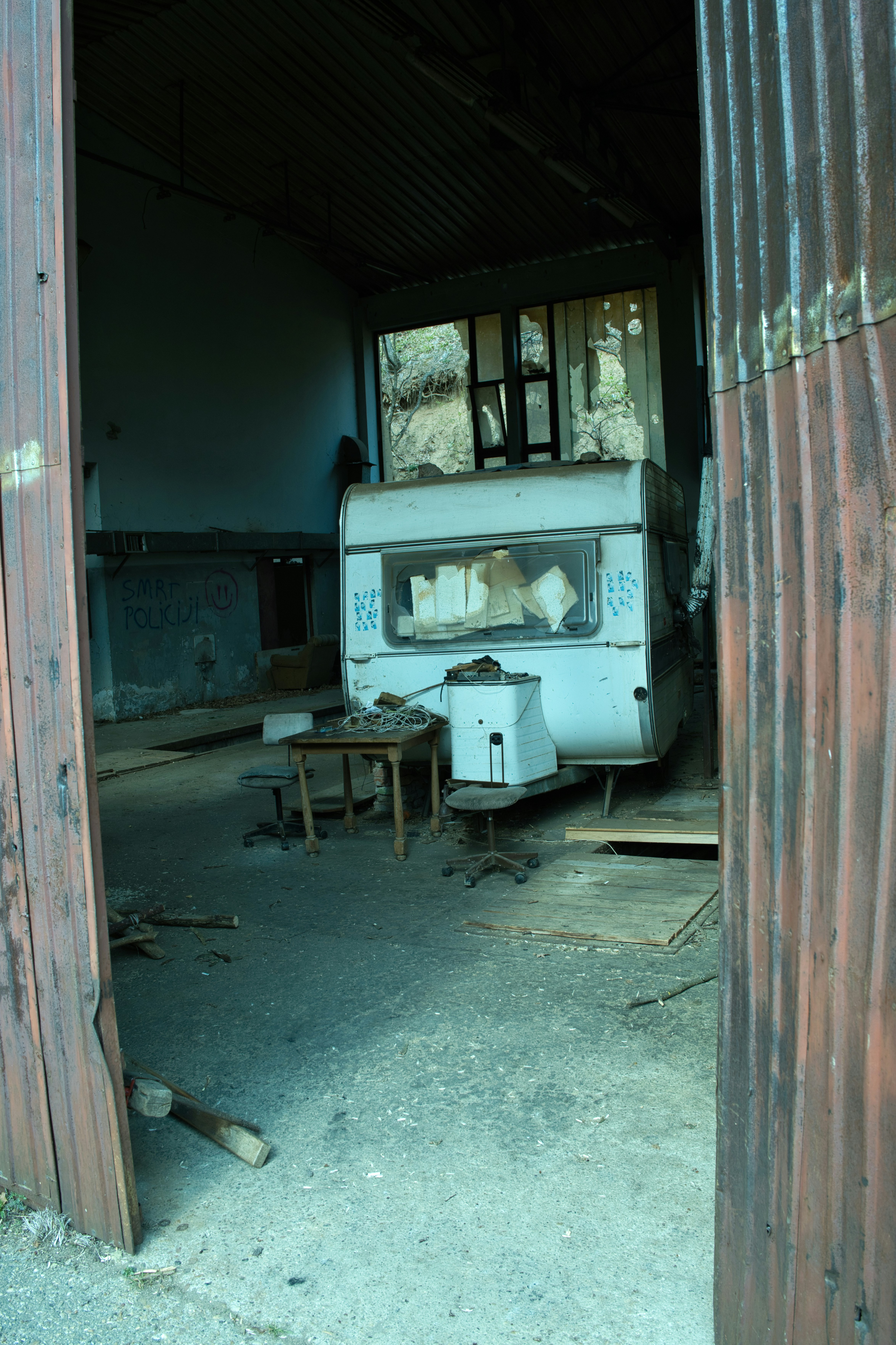 Abandoned Caravan Inside a Weathered Workshop