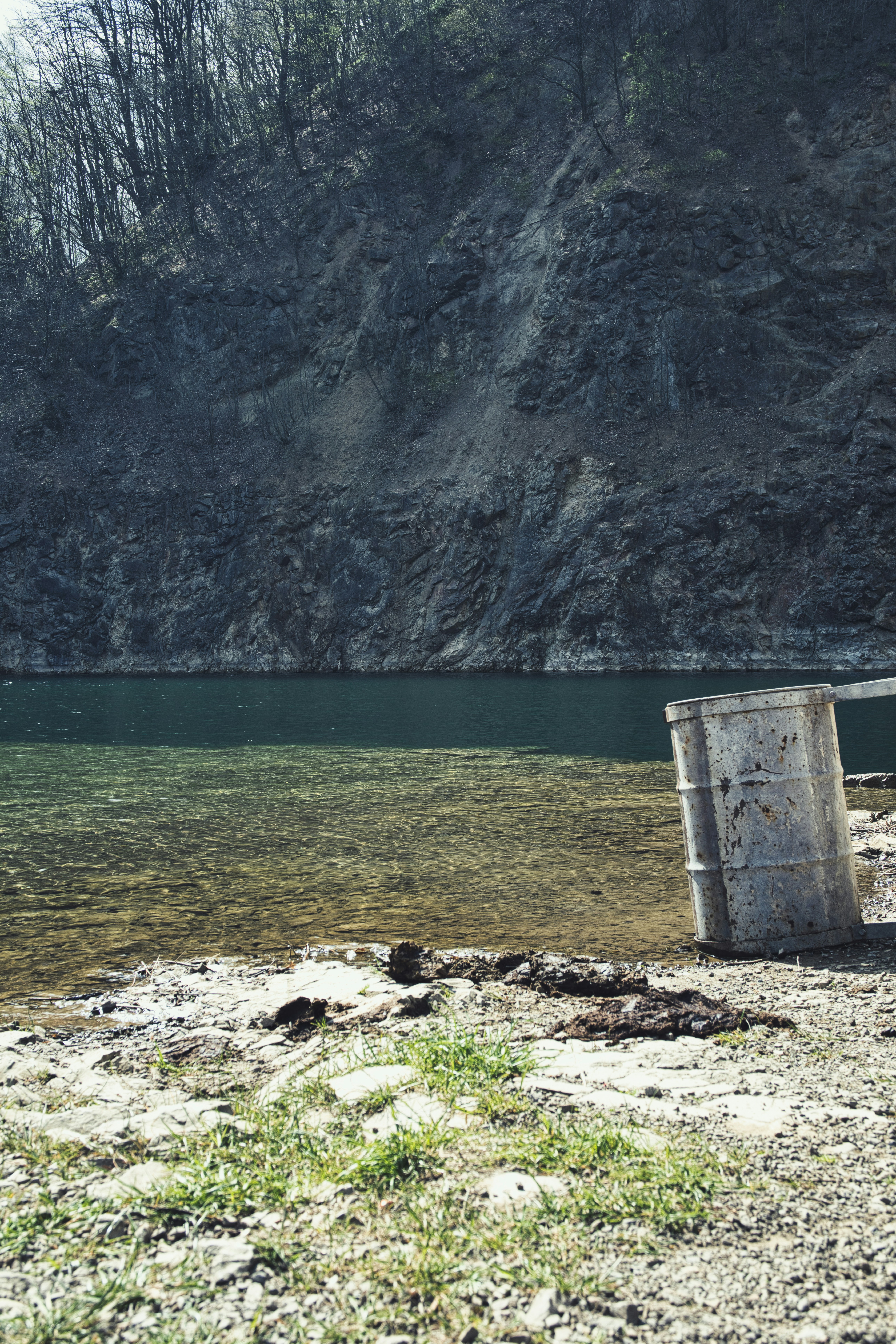 Quiet Reservoir Edge with Rusted Barrel by Shore