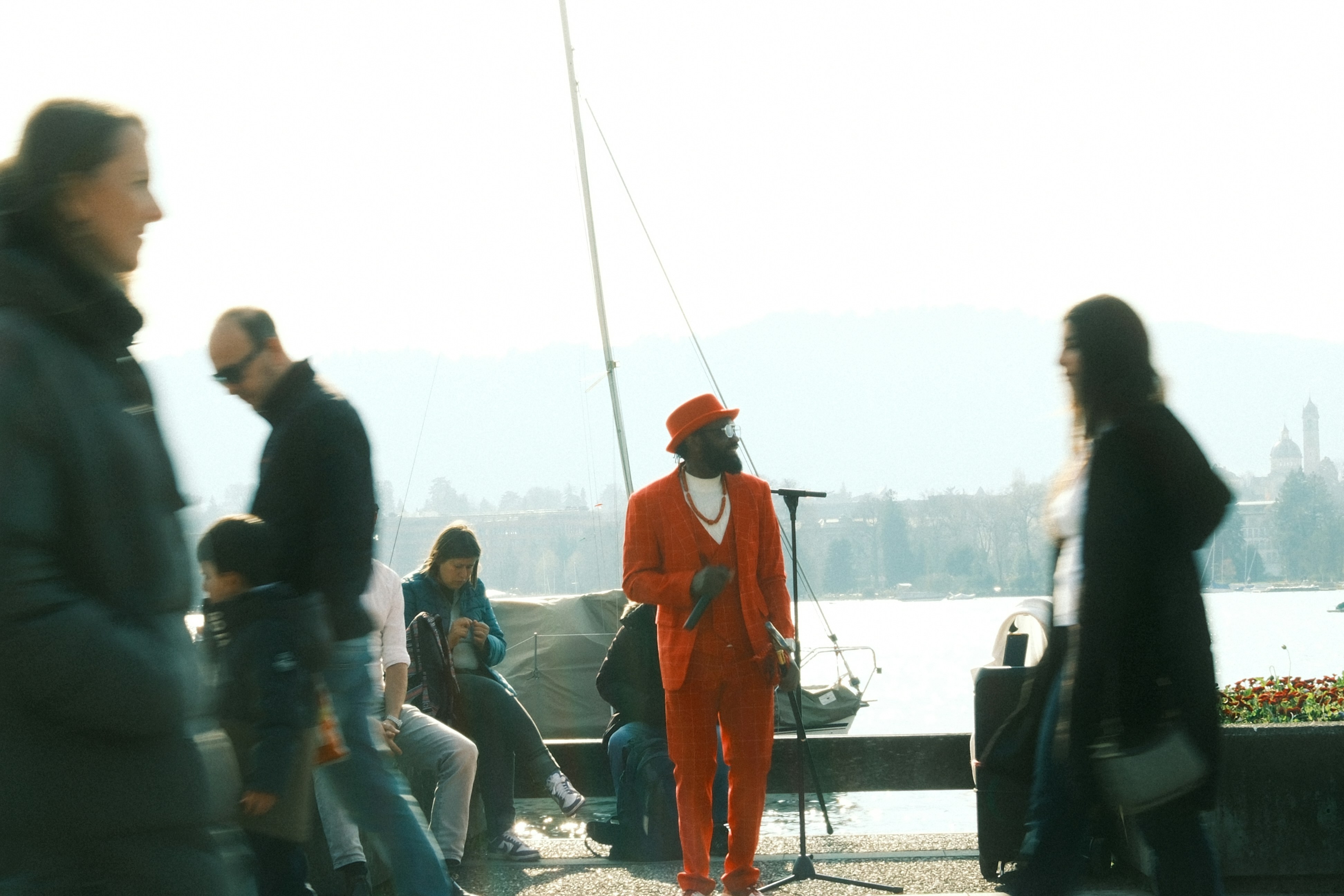 Red Suit at the Edge: Street Musicians and Passersby by the Waterfront