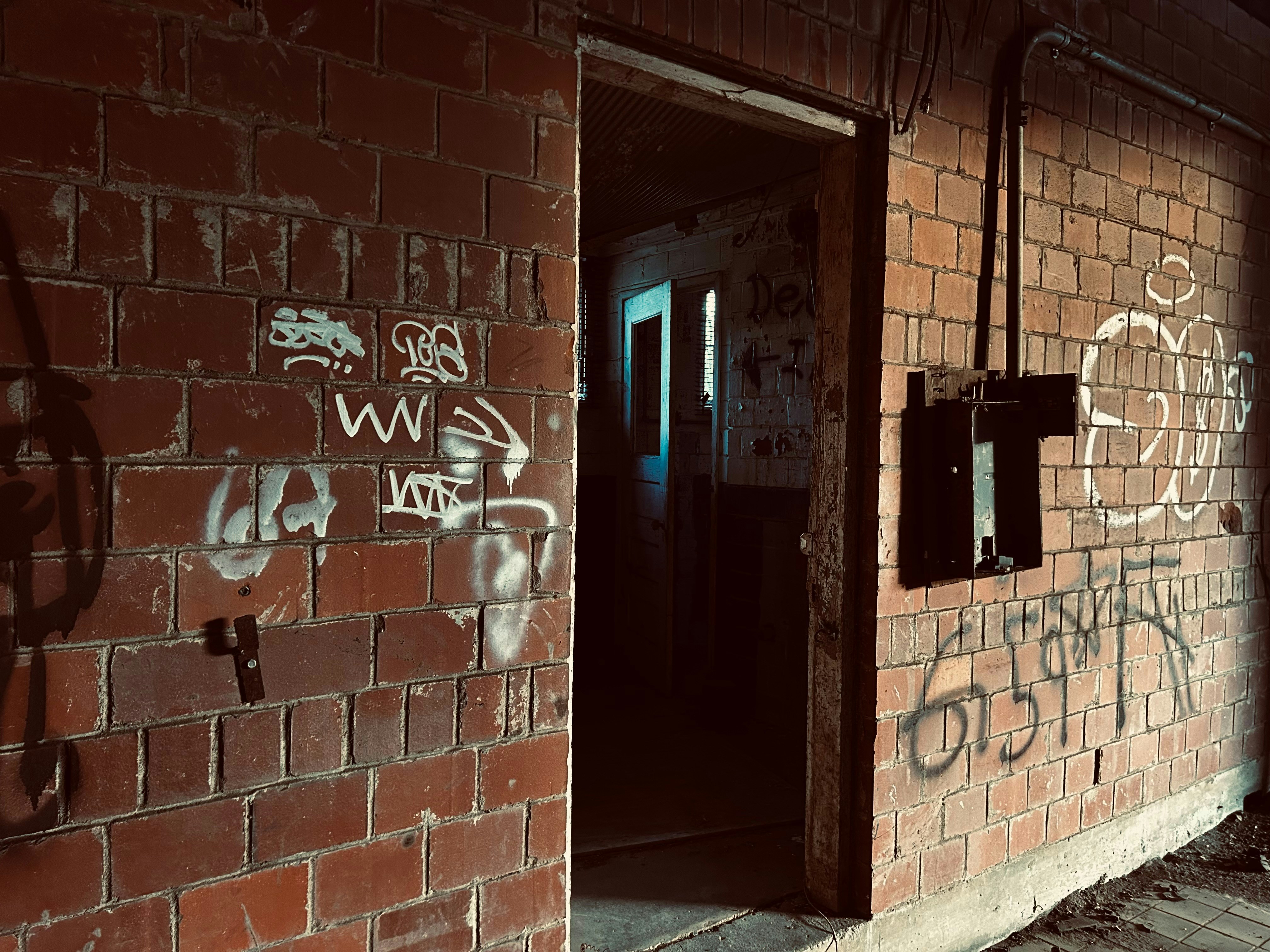 Partial doorway into a graffiti-streaked tunnel