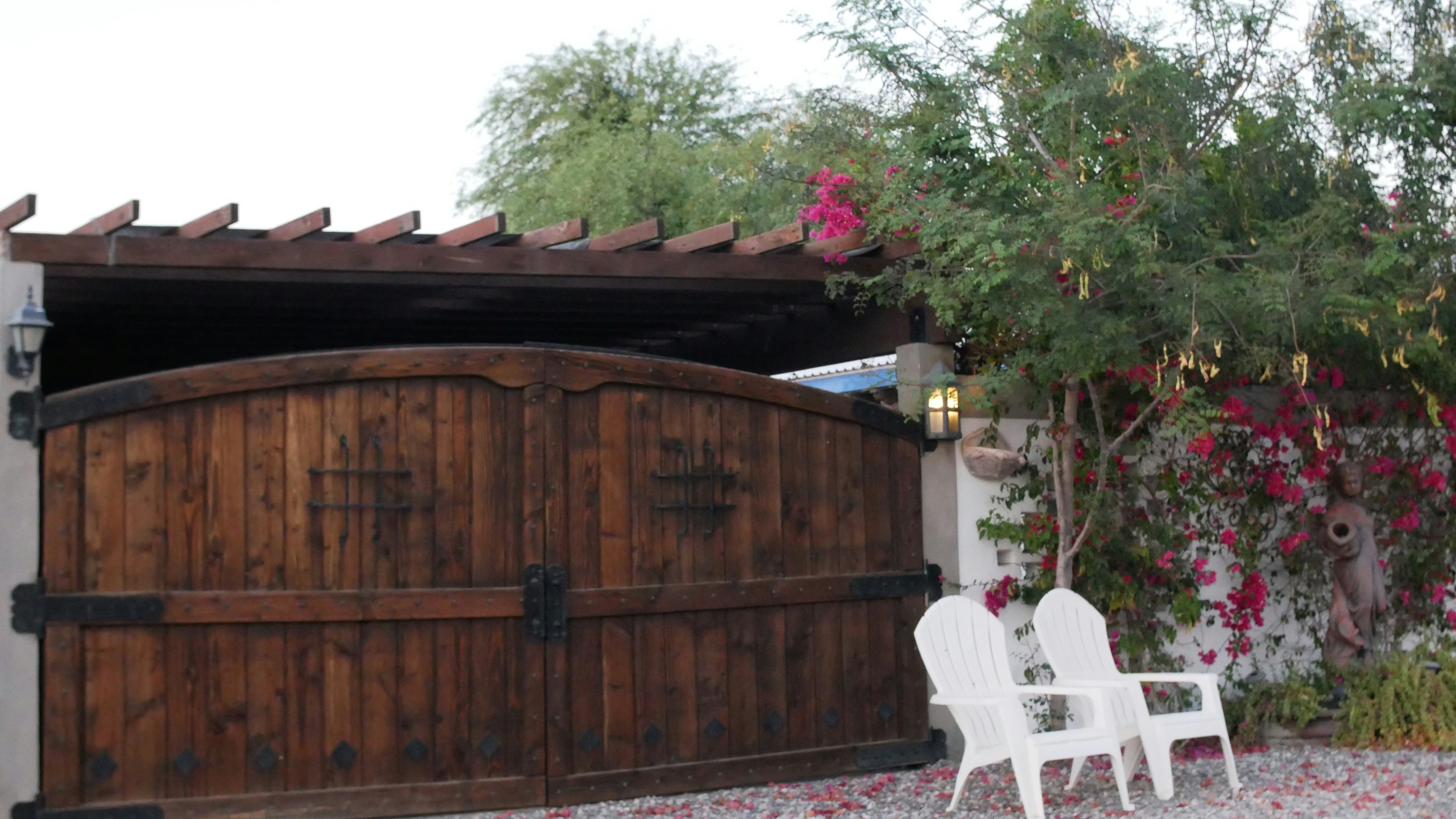 Wooden Gate Shelter with Bougainvillea and White Chairs