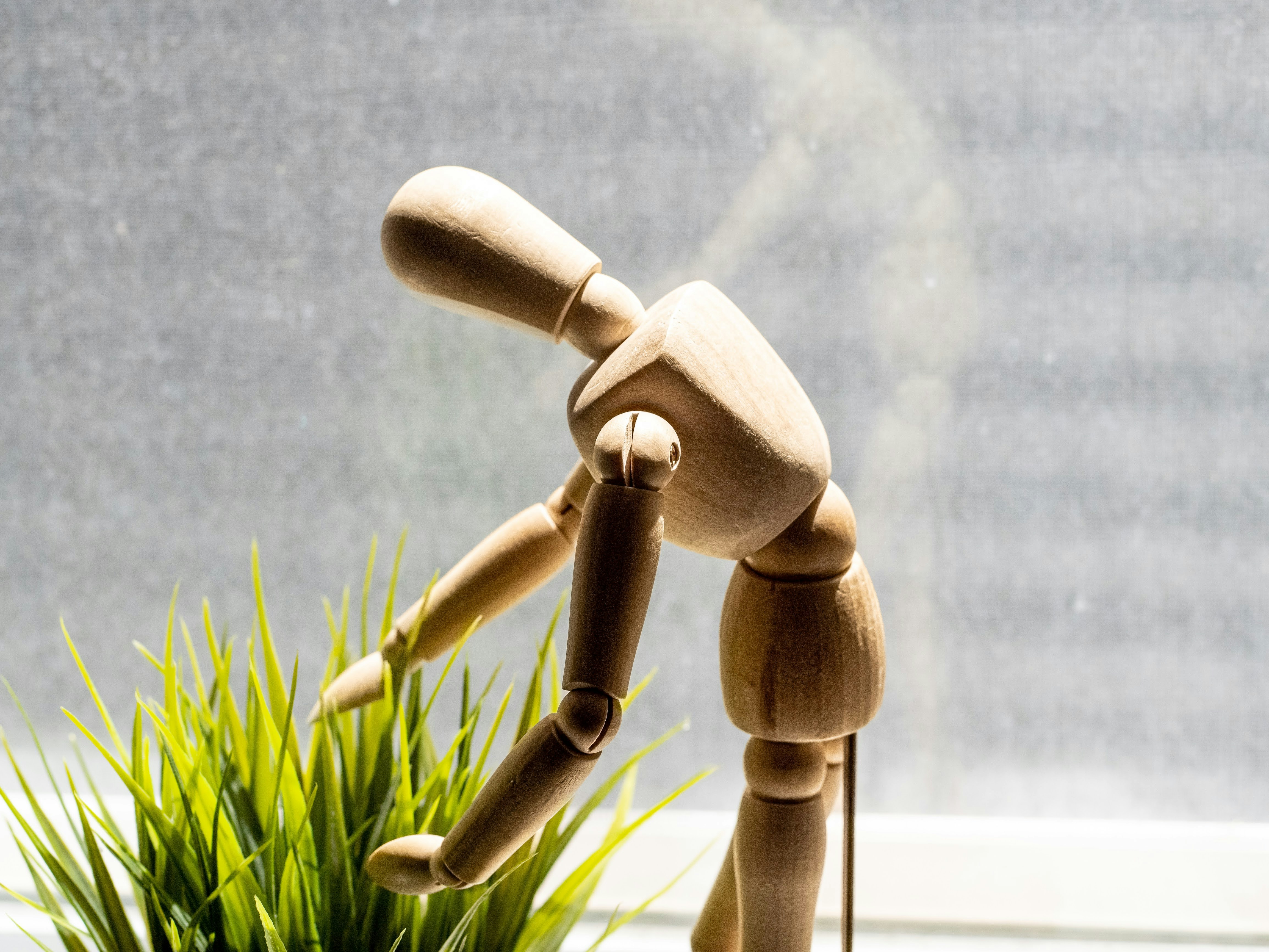 Lifelike Wooden Figure Reaching from a Sunlit Window
