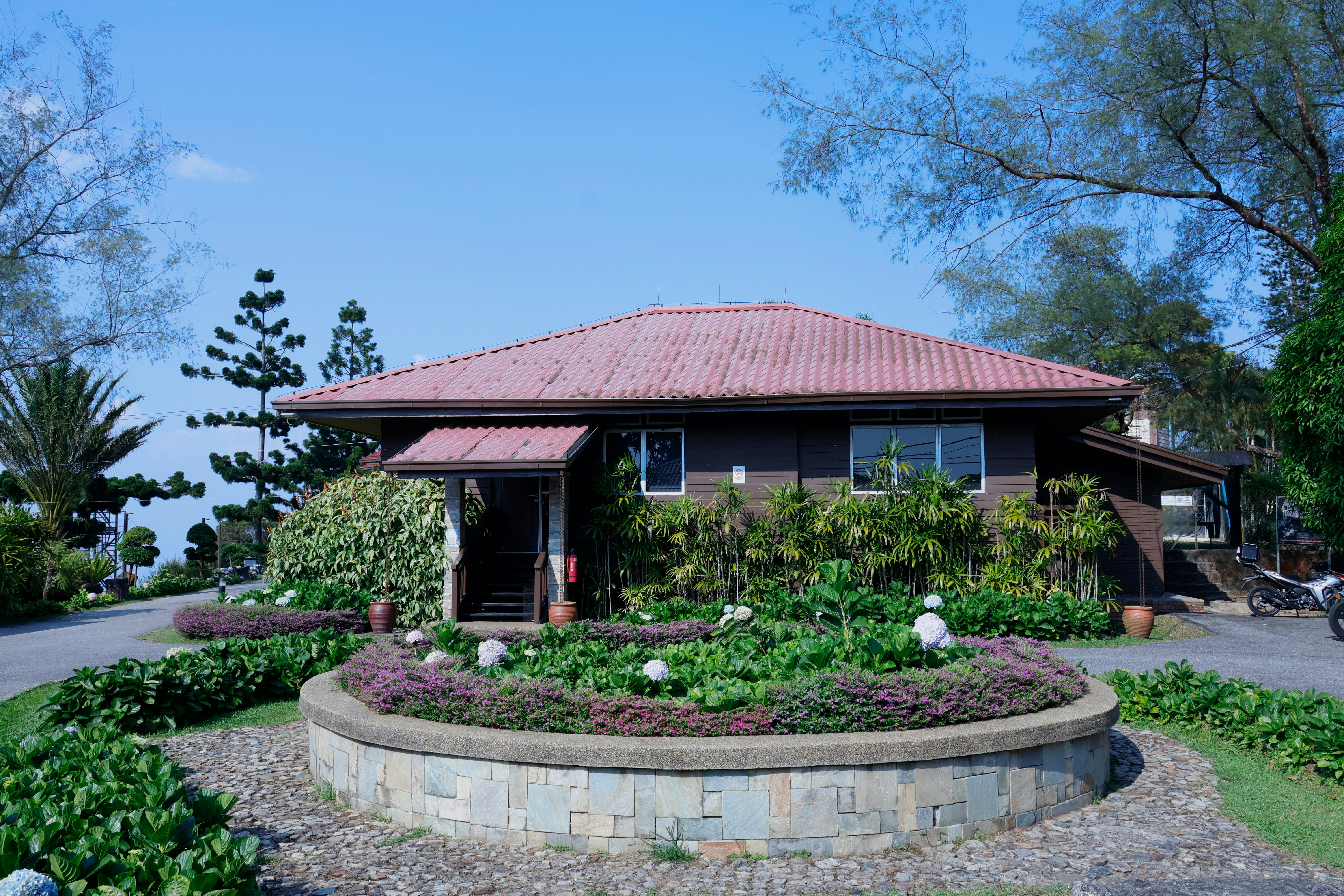 Circular Flowerbed Framing a Single-Story Red-Tiled House