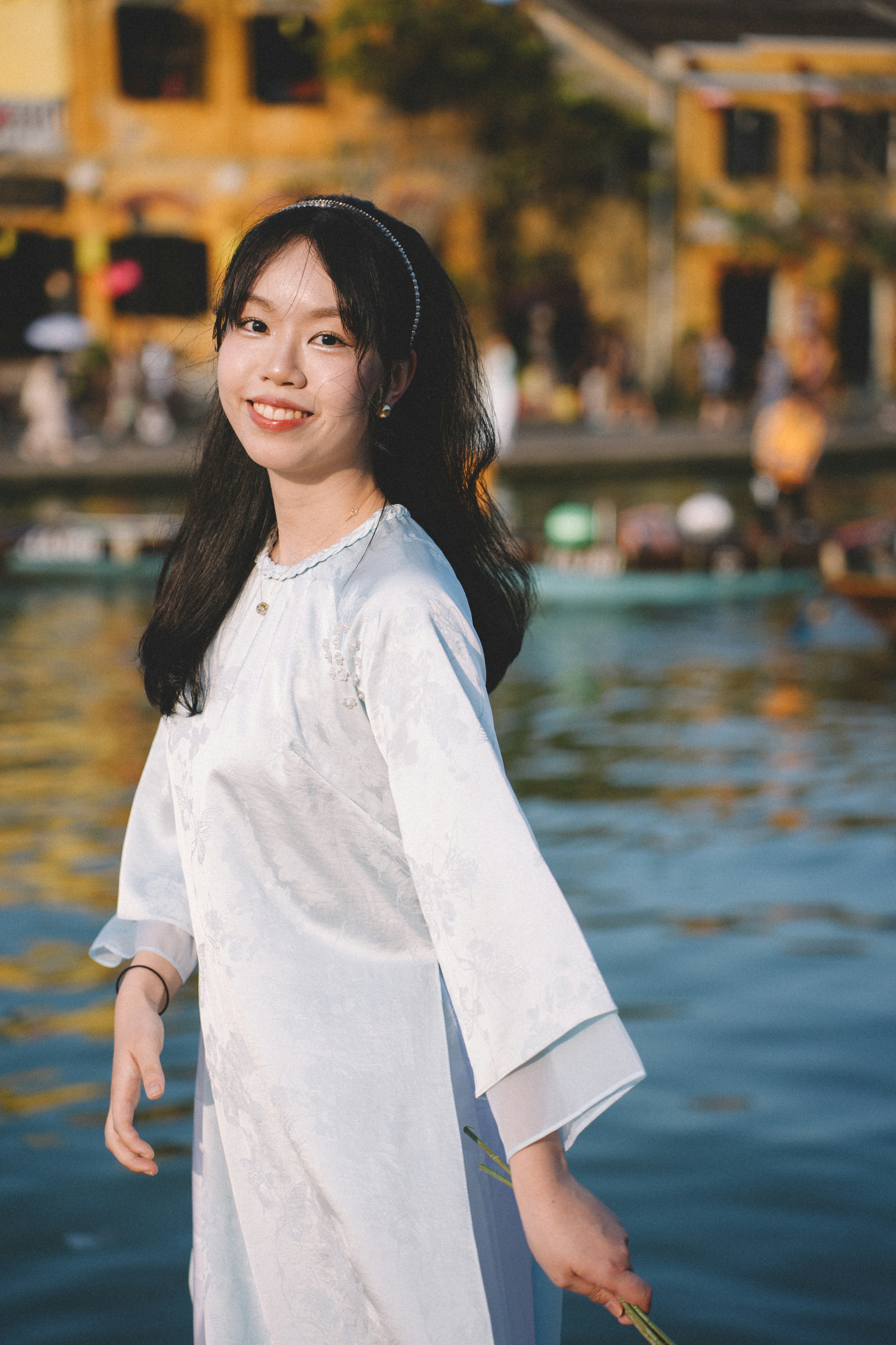 Graceful portrait by the water: a smiling moment in white