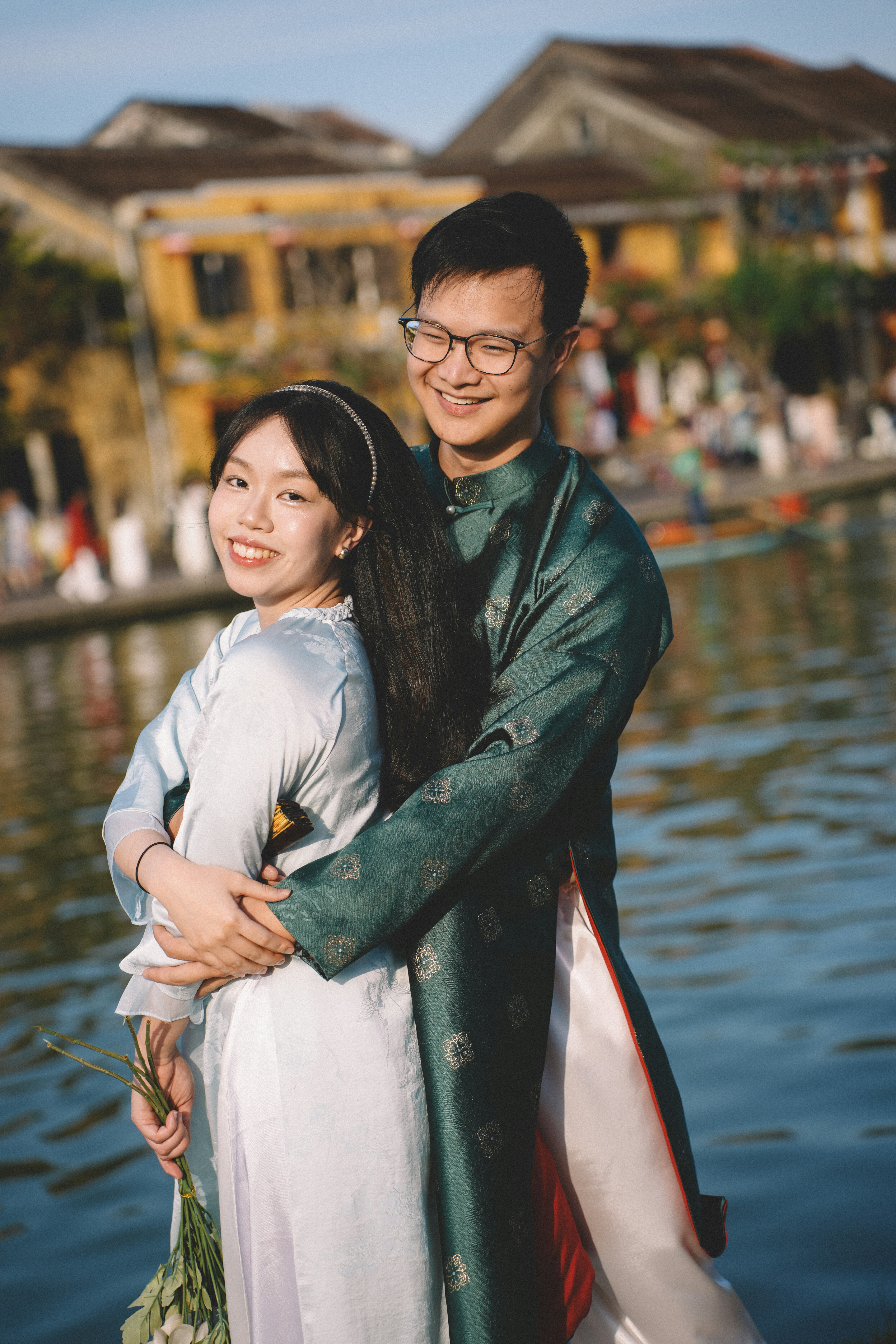 Embrace by the Water: a Couple in Traditional Attire