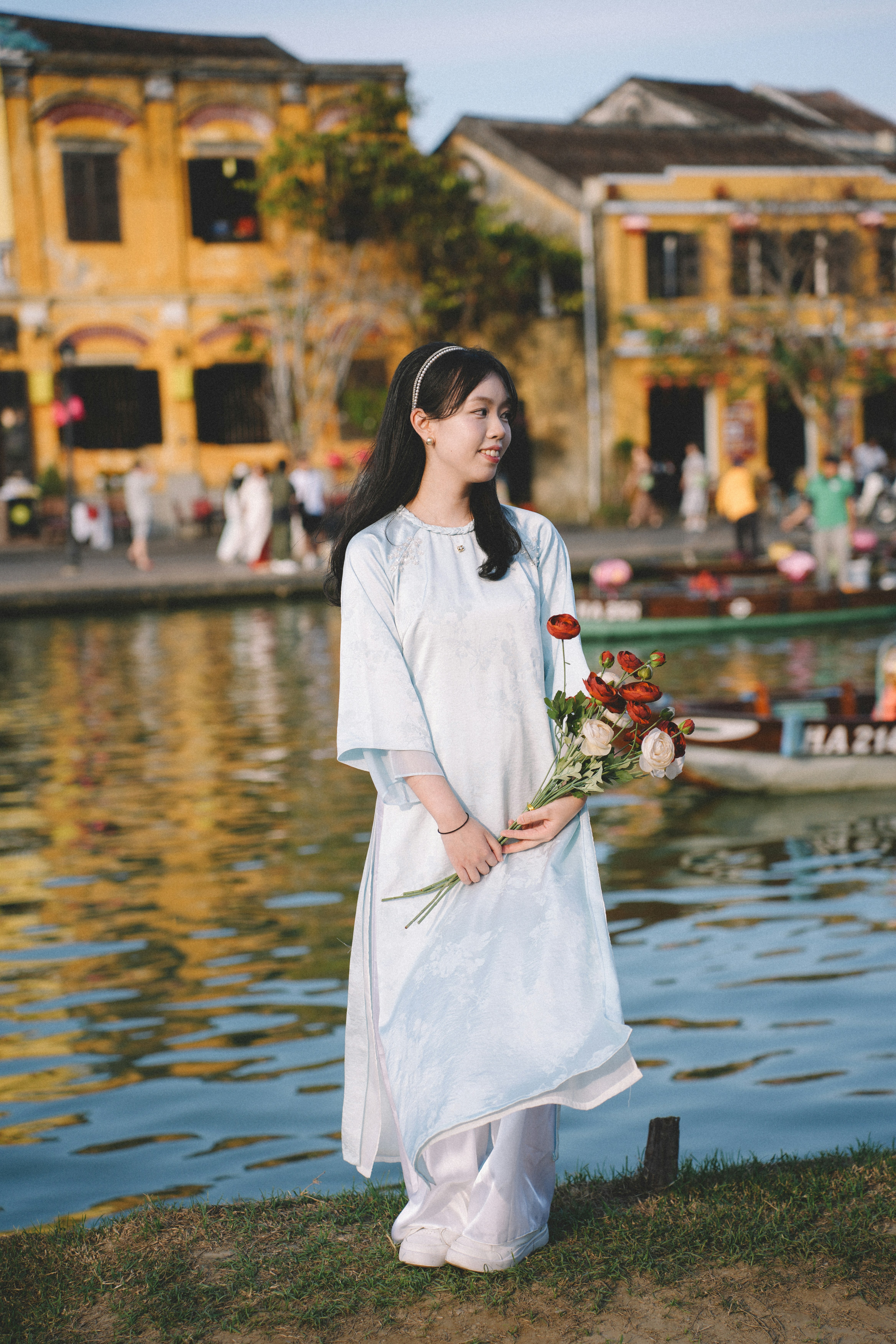 White dress by the water: a quiet portrait before the village backdrop