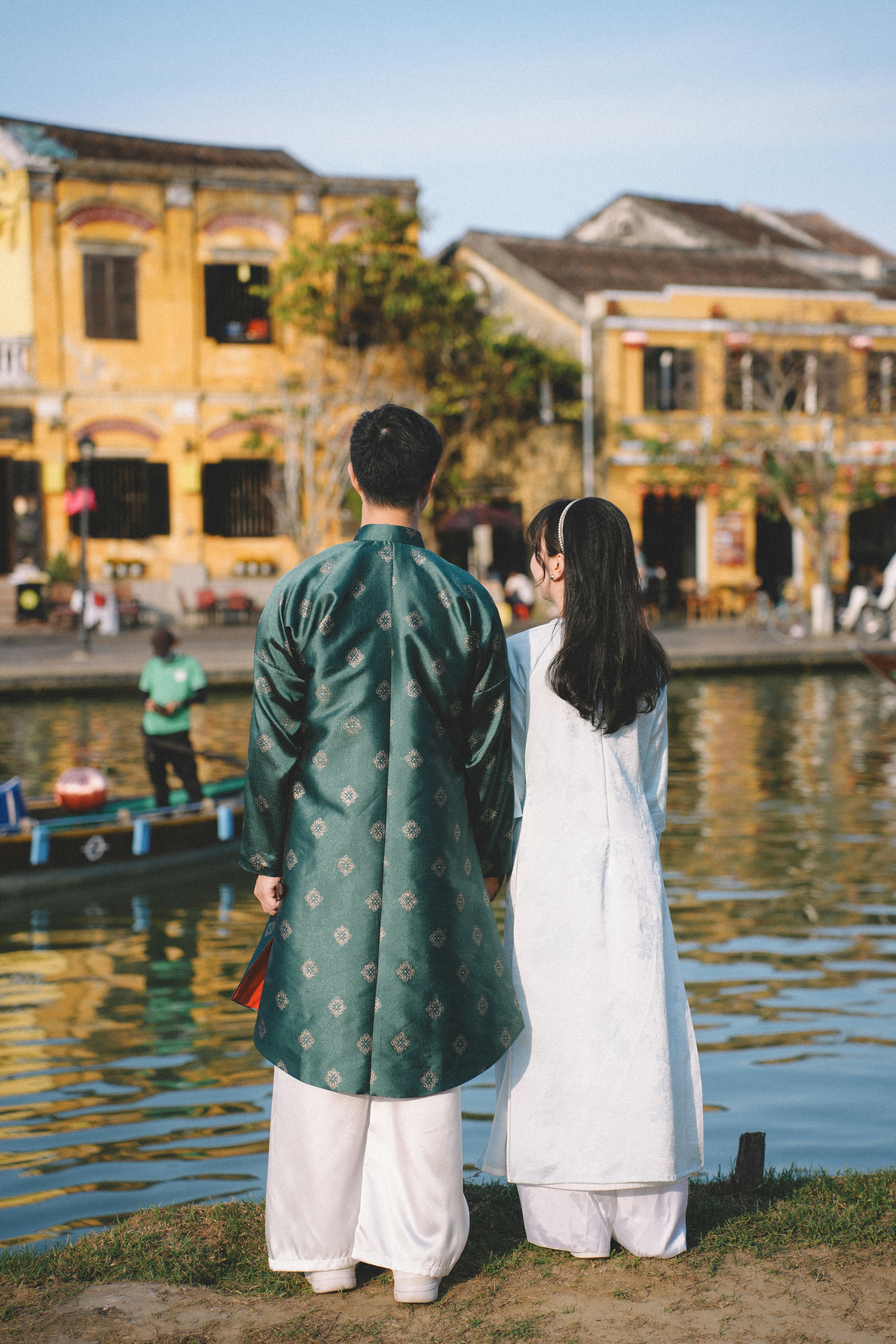 Couple in traditional attire by the canal, A Vietnamese riverside moment