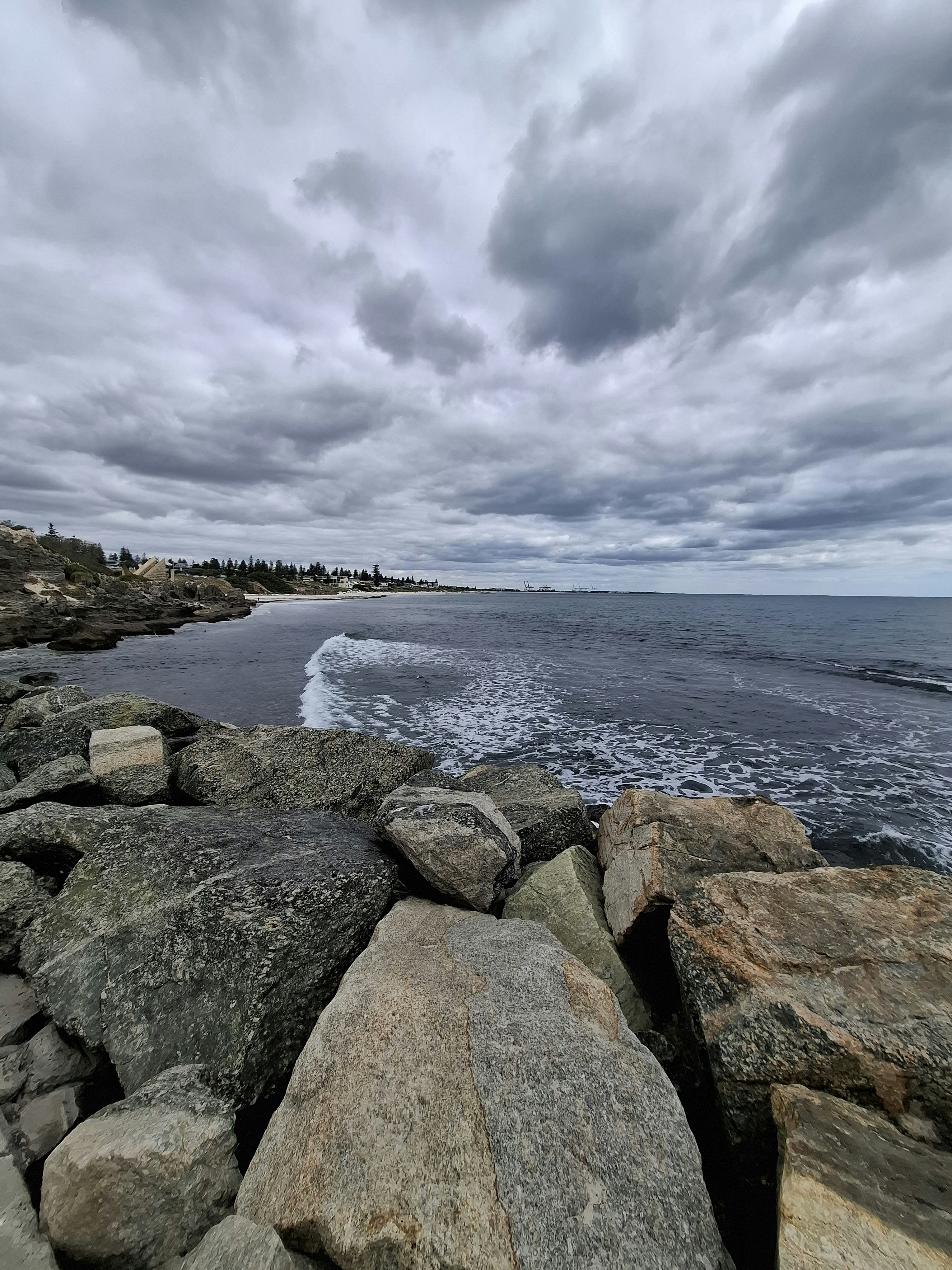 Rugged Seaside Breakwater Under A Brooding Sky