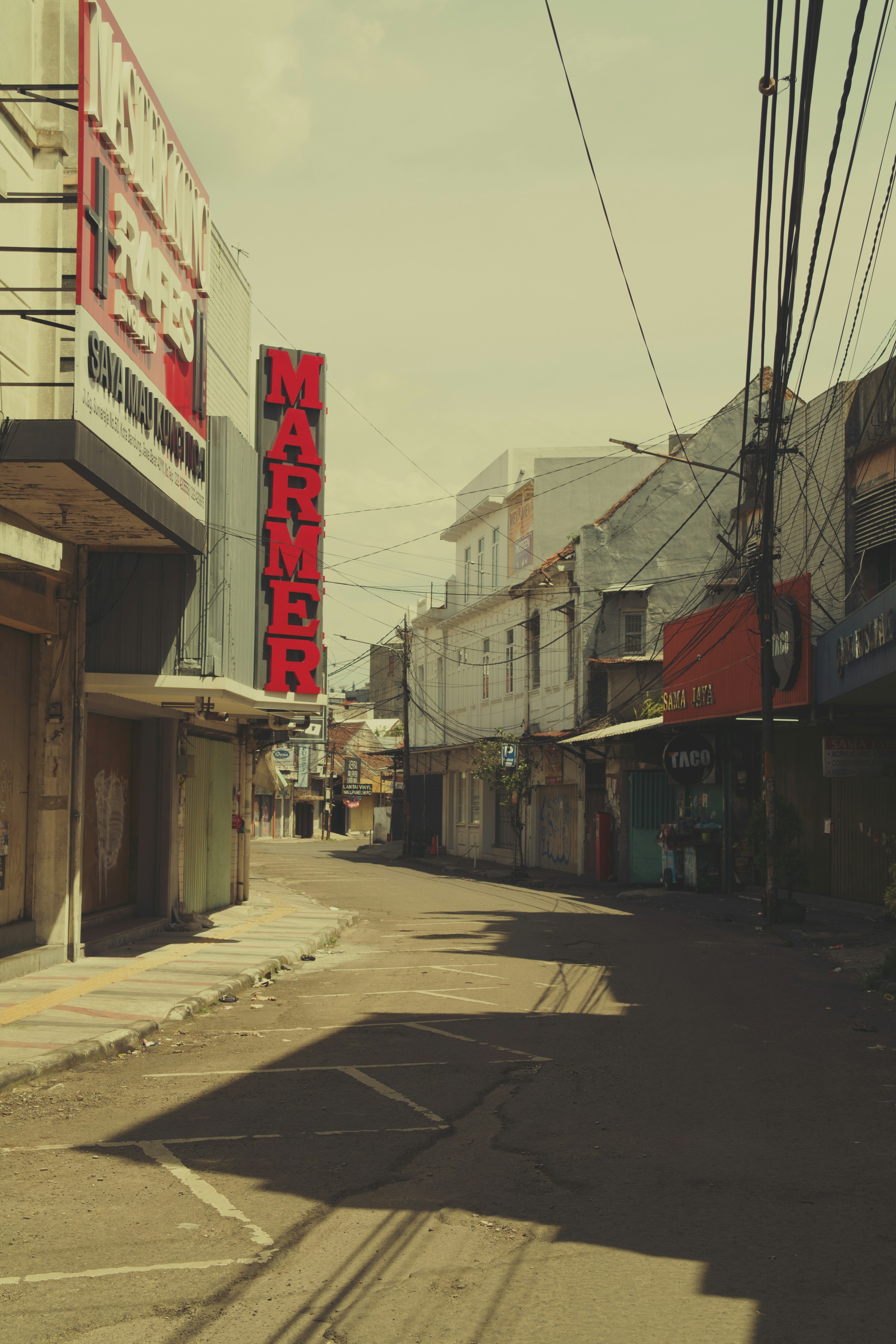 Neon-Red Sign Against a Quiet Street Corridor