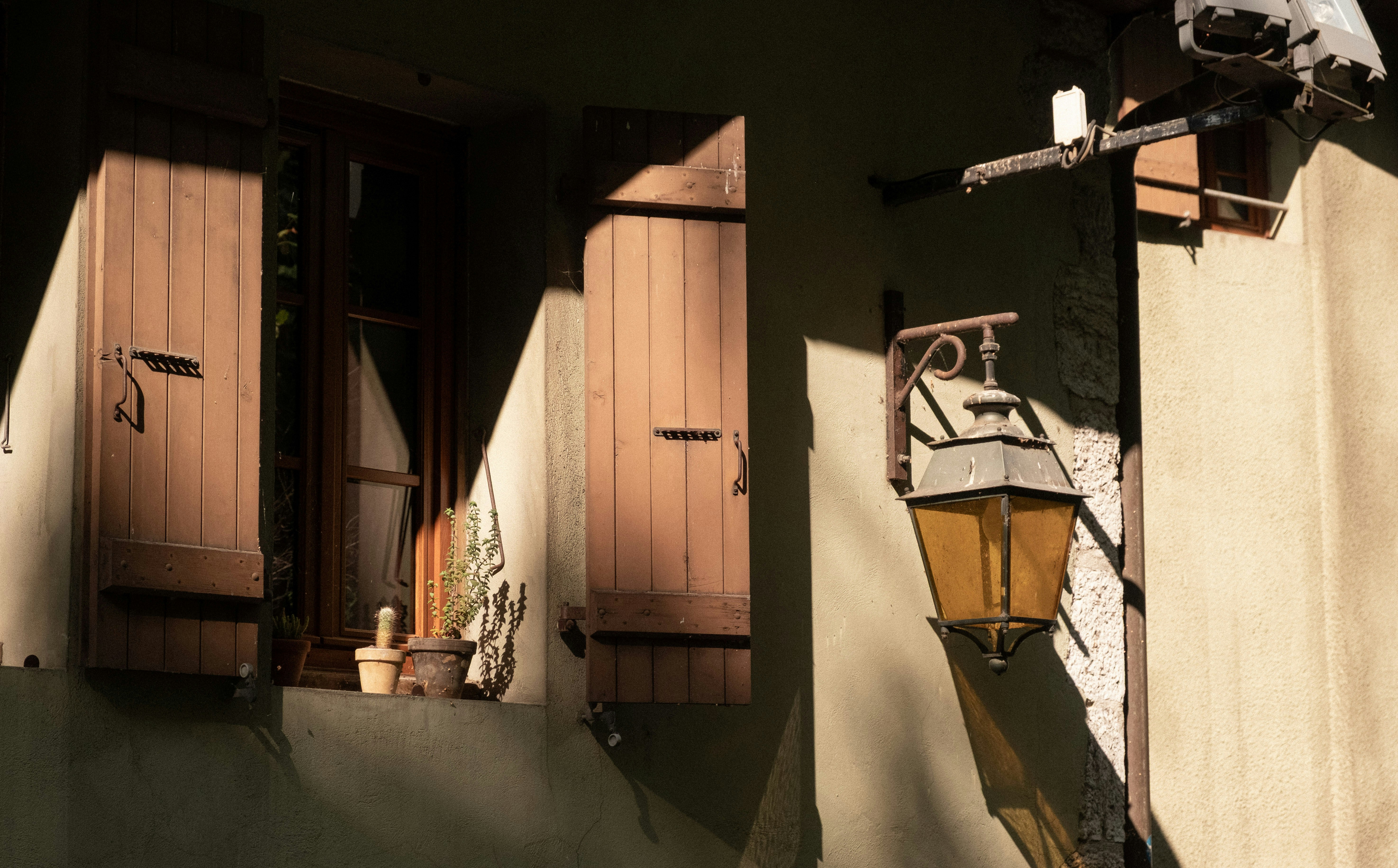Sunlit Rustic Window with Lantern and Potted Plants